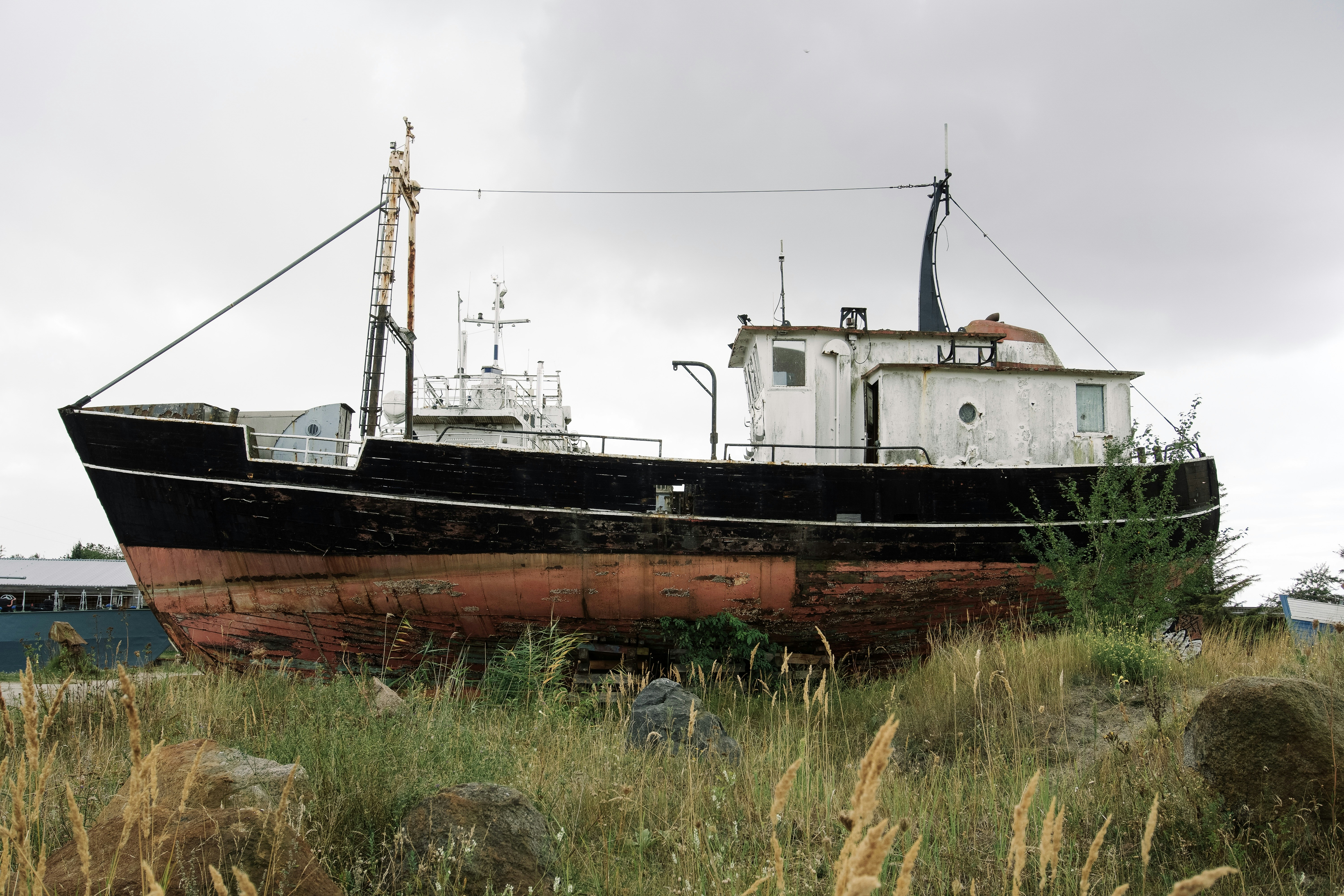 Sunken Hunter: The Weathered Vessel Resting in Idle Grass
