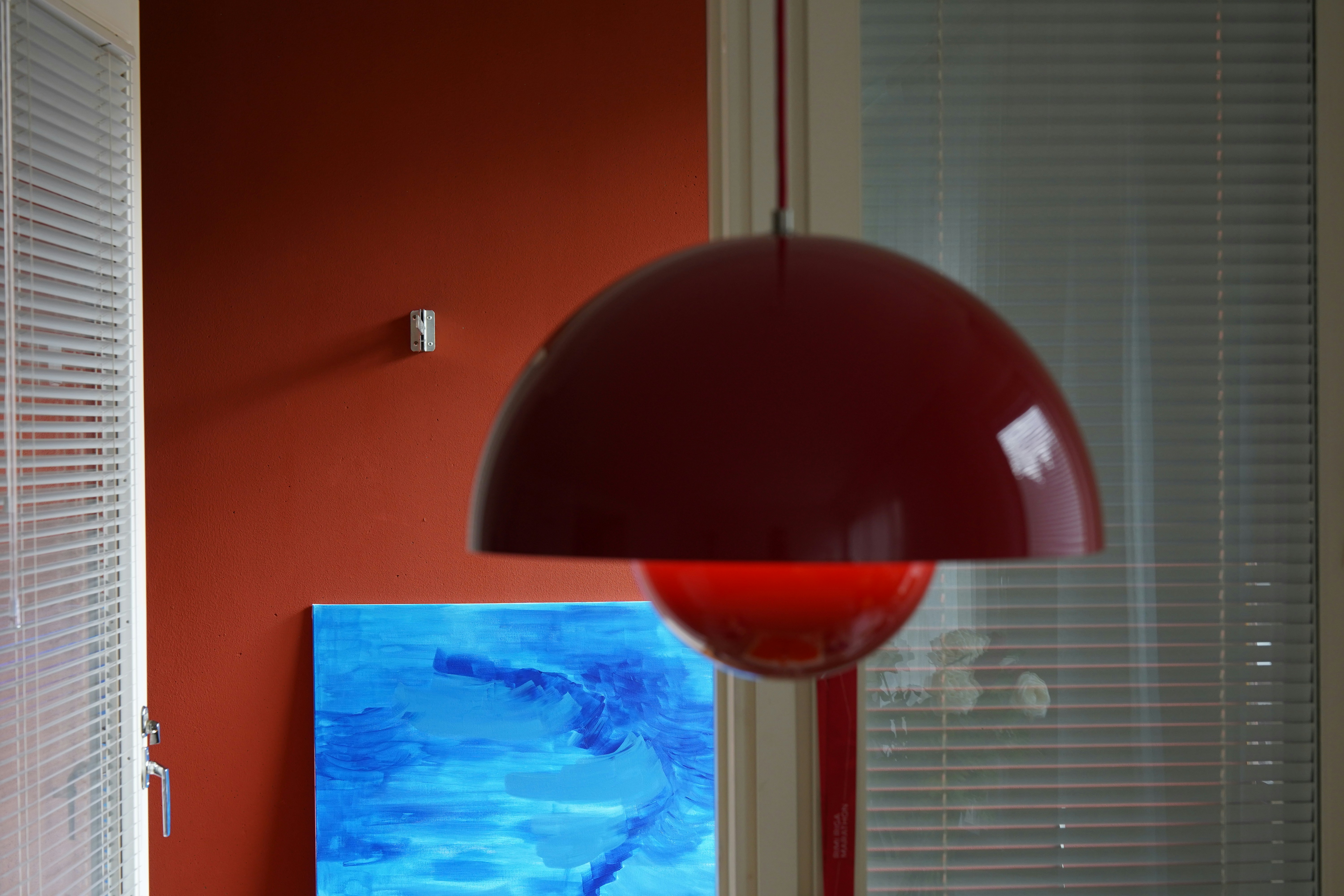 Red Globe Over a Blue Canvas: A Quiet Interior Portrait