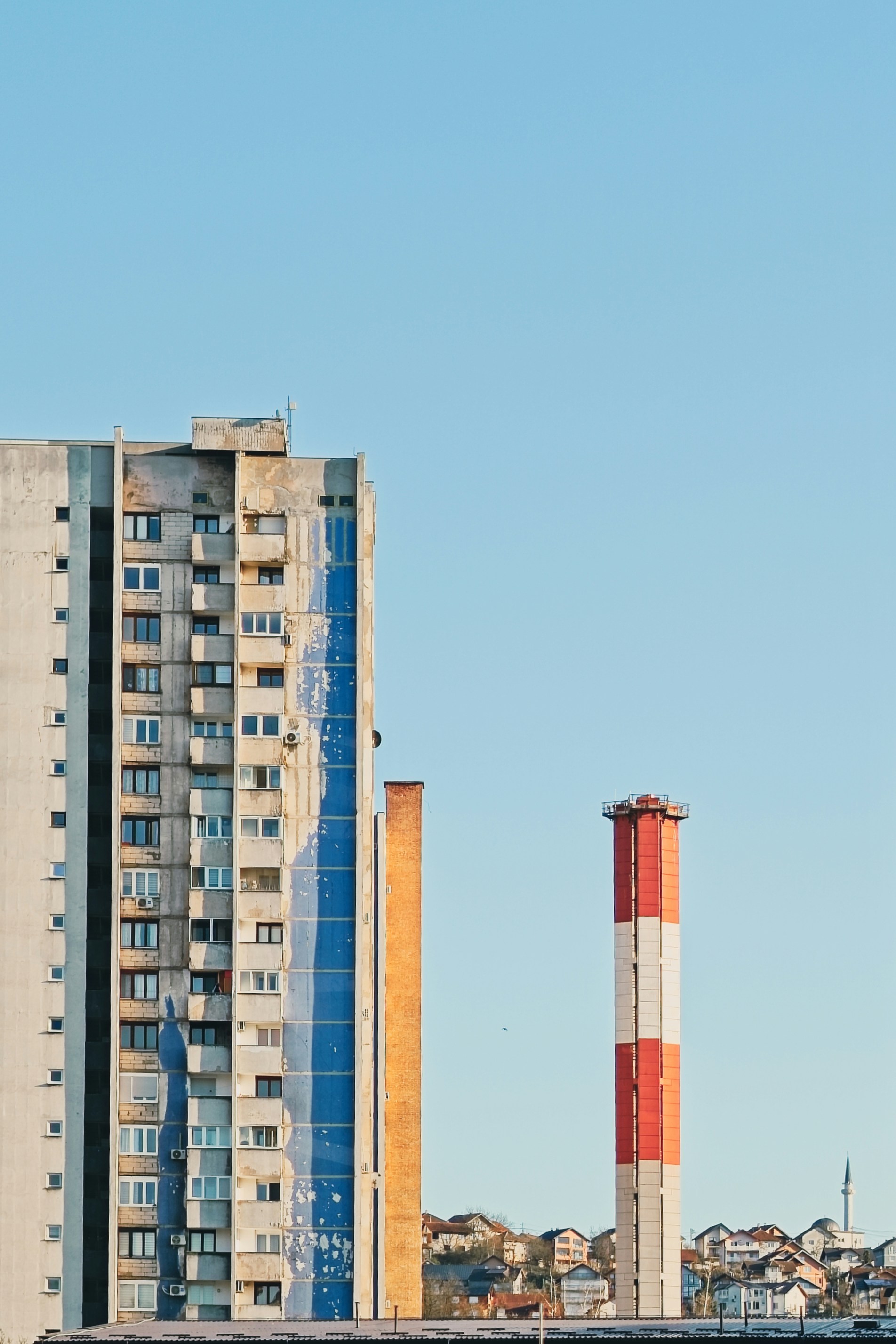 Vertical Cityscape: Two Contrasting Chimneys Against a Clear Sky