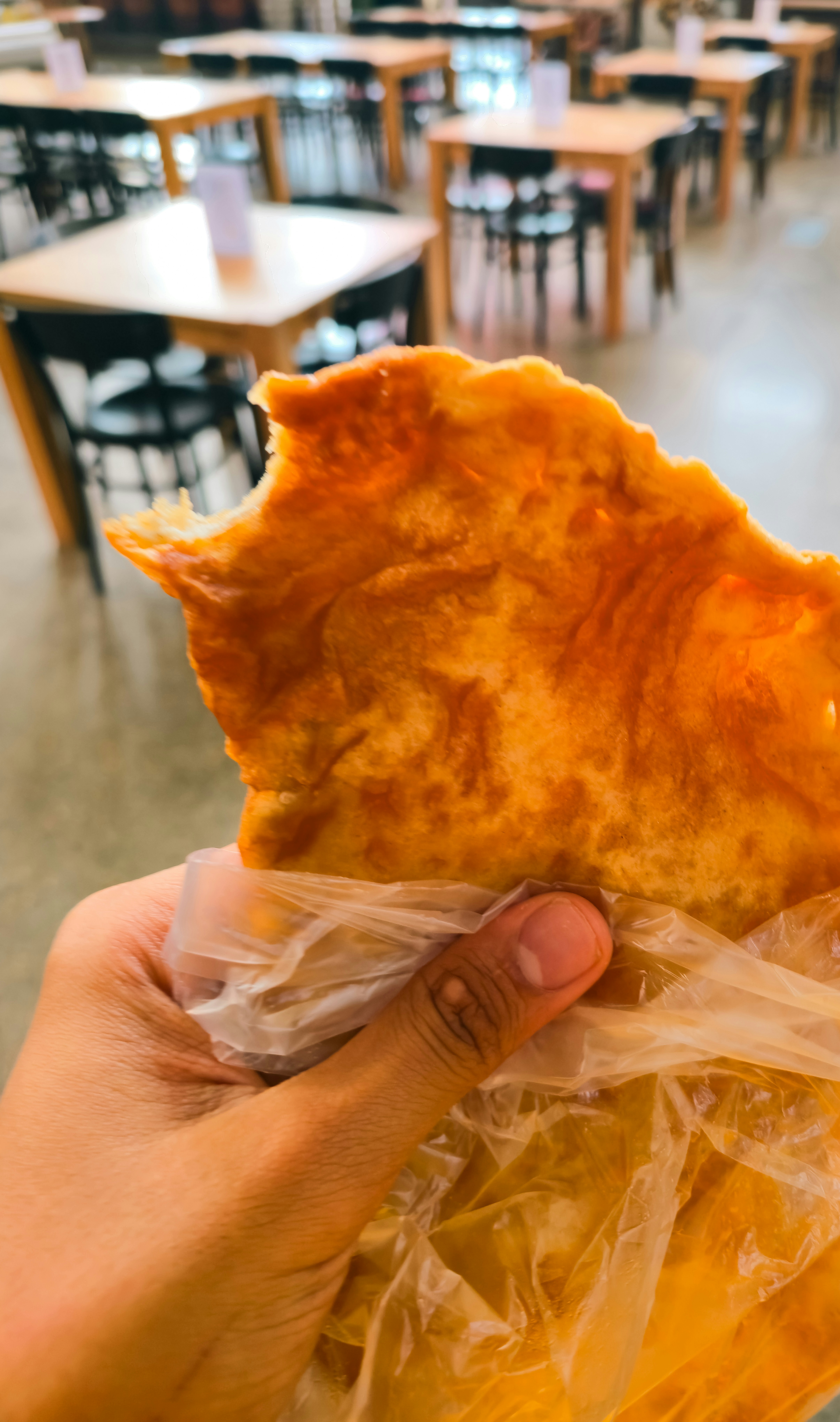 Crunch of Crispness: A Handful of Golden Snack in a Quiet Café