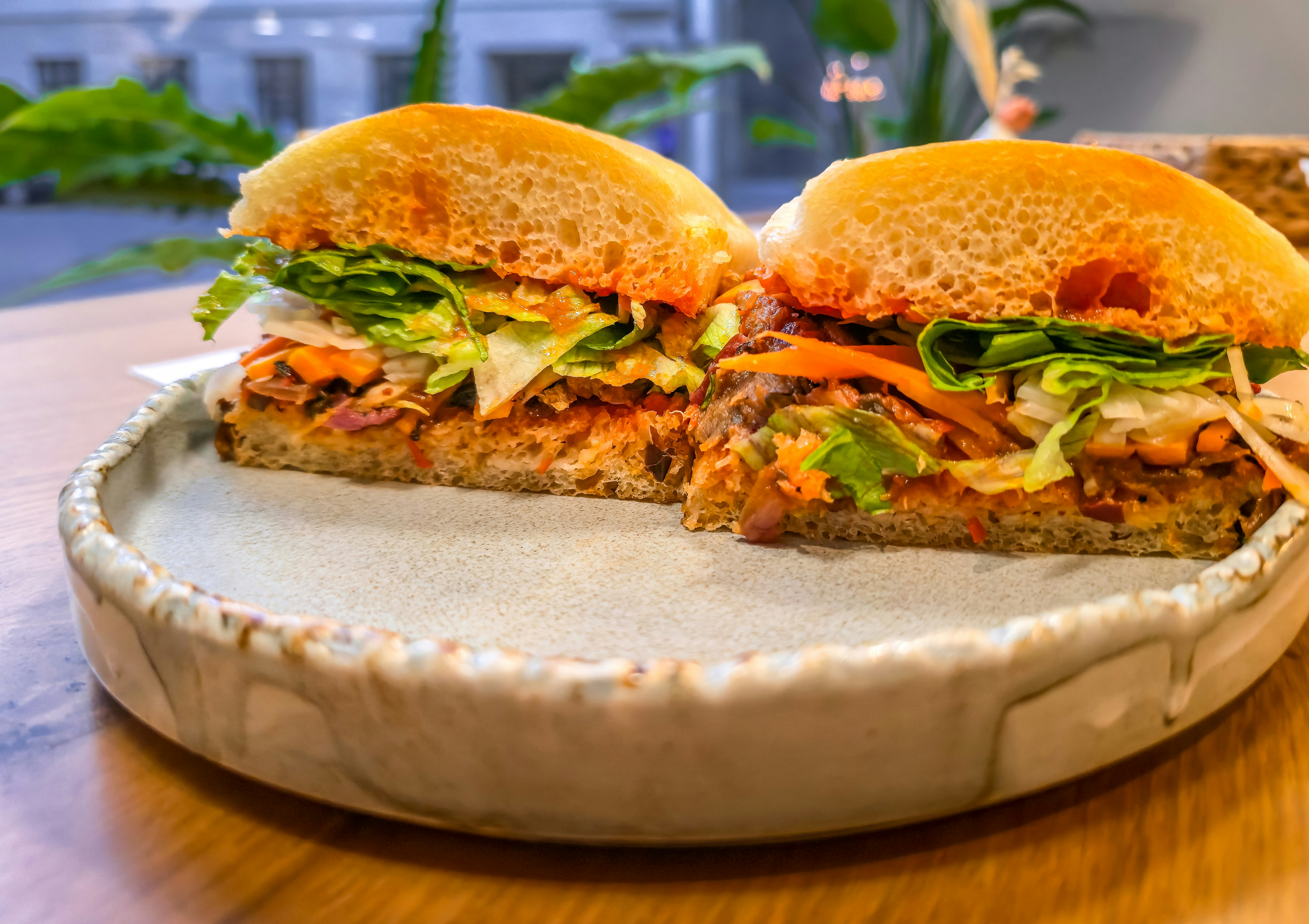 Sunny Deli Stack: A Savory Duo of Mini Burgers on a Ceramic Plate