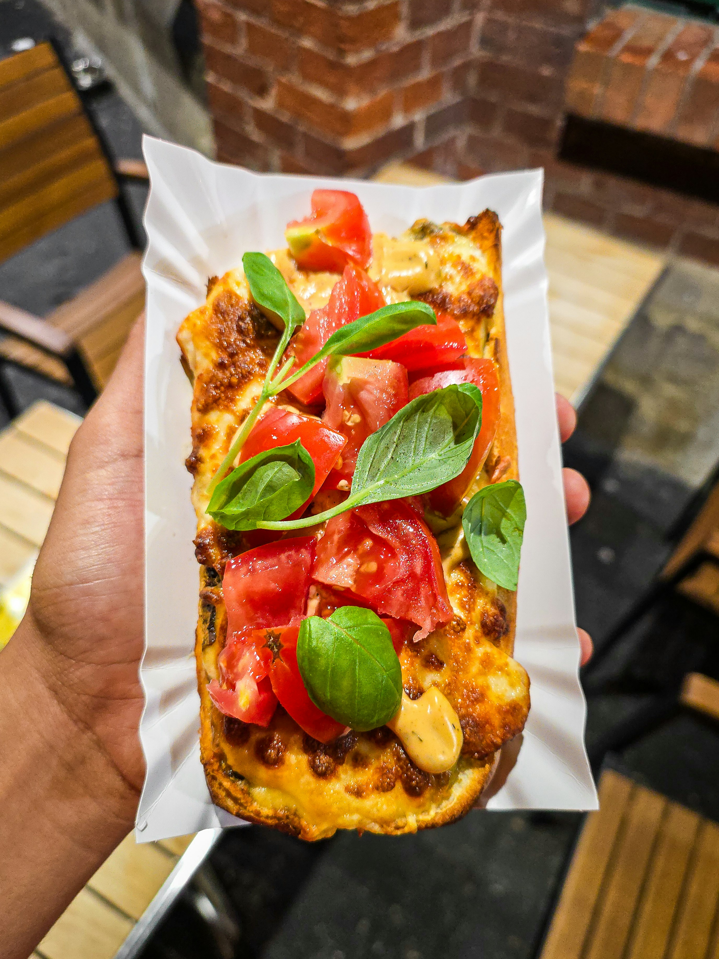 Heritage Pizza Bite: A Crisp Cheese Slice Crowned with Tomatoes and Basil