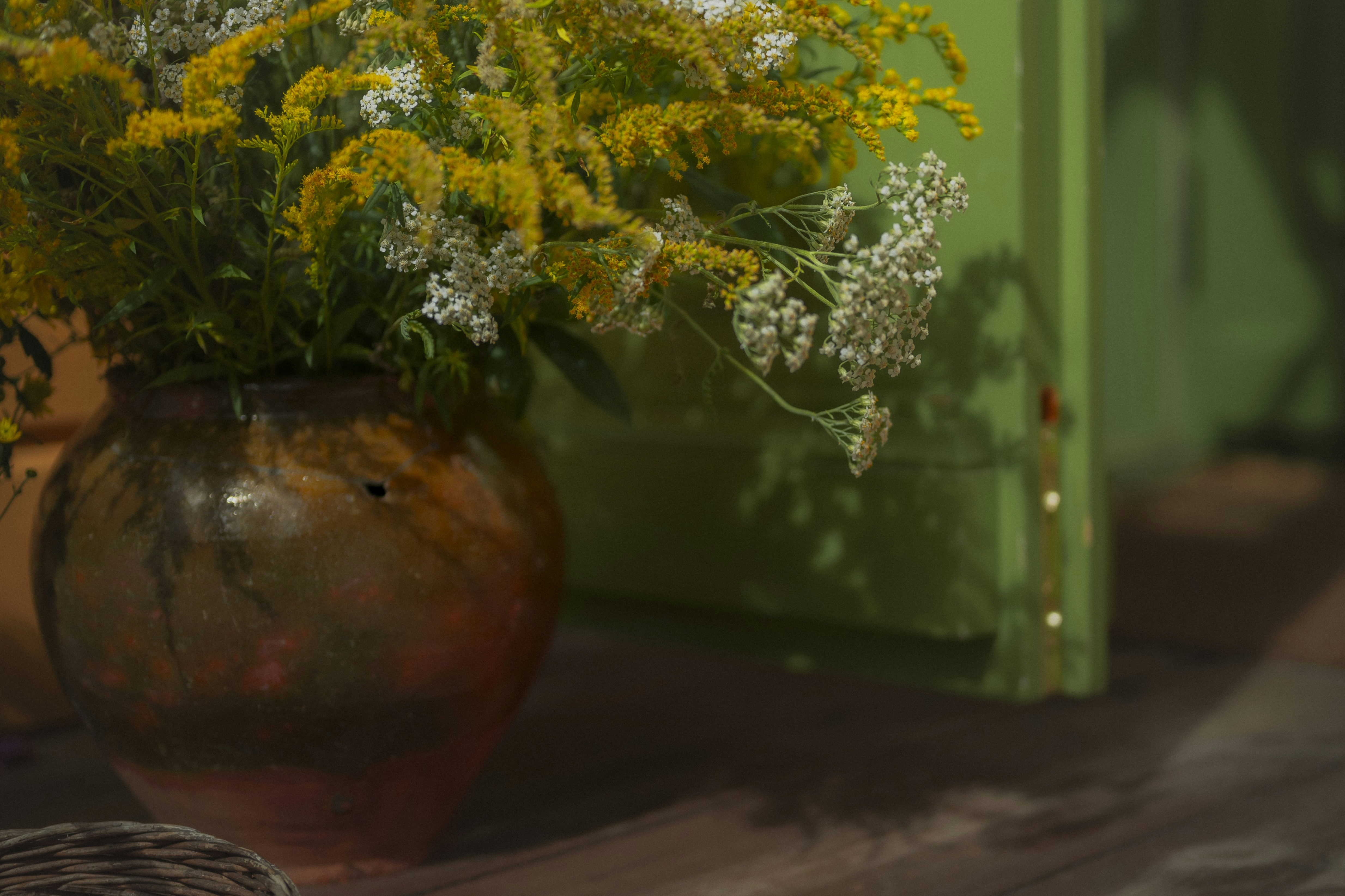 Ceramic Vase with Wildflowers on a Sunlit Table