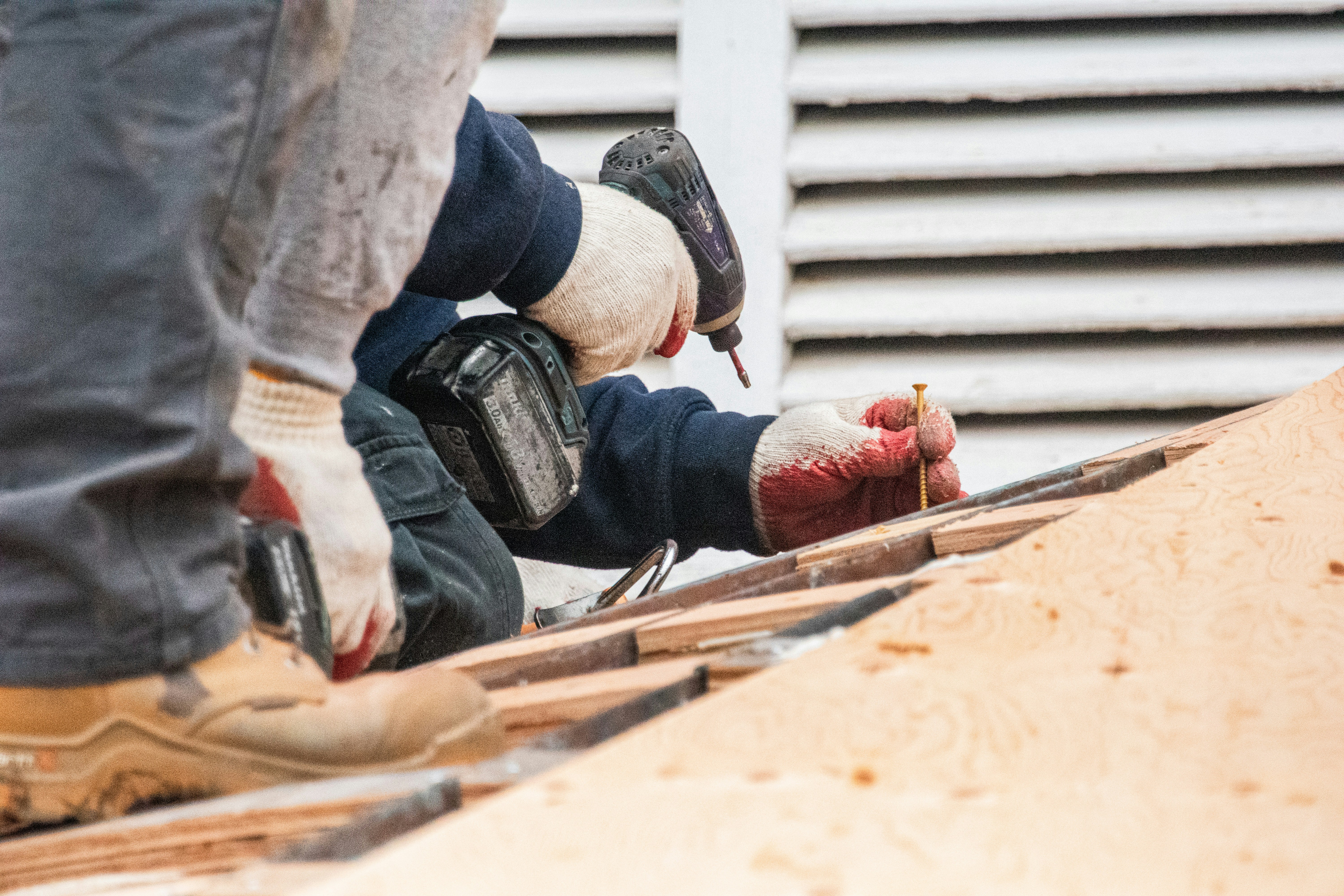 Hands at Work: Drilling and Securing Damaged Roof Planks