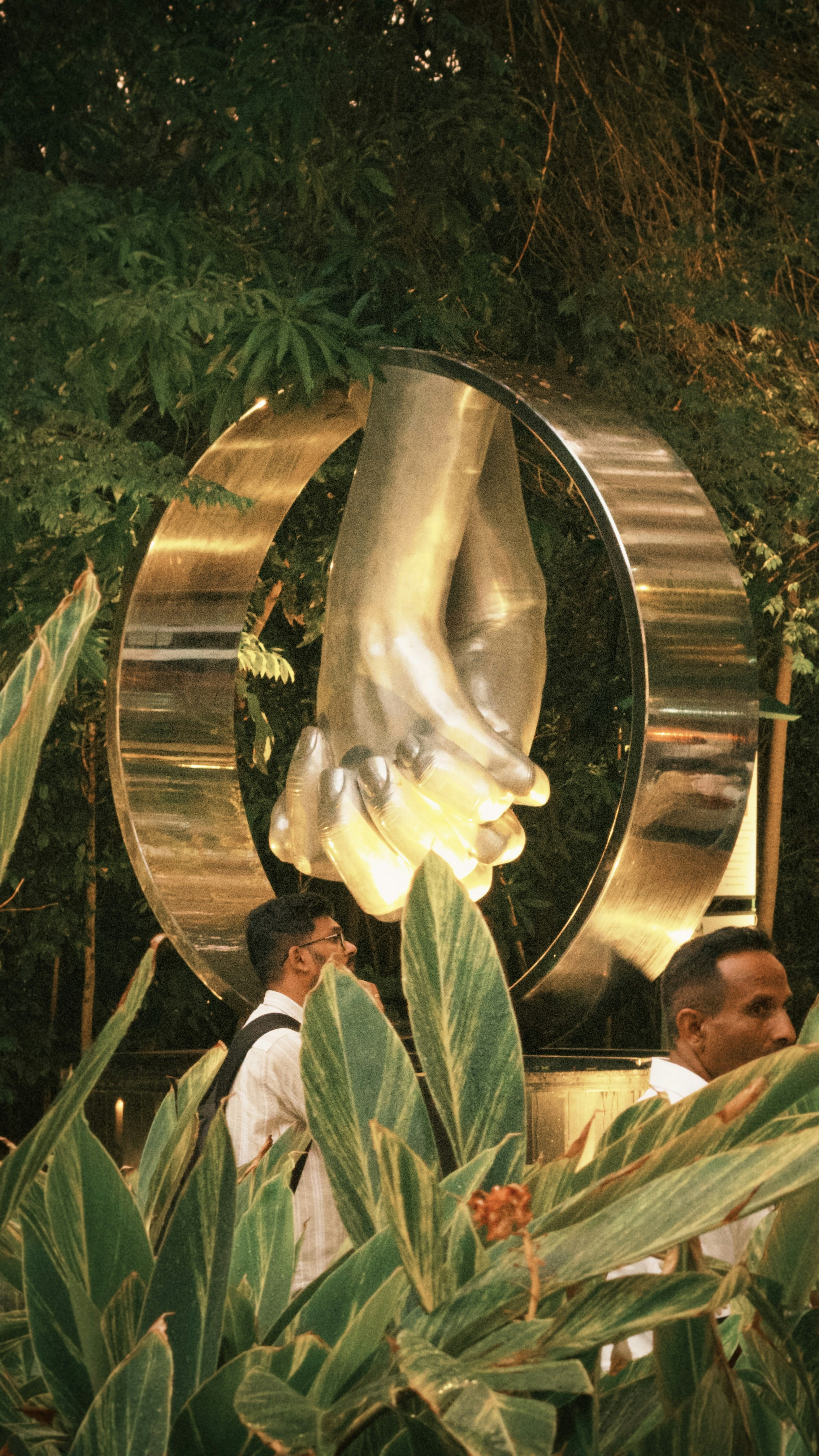Hands in Bronze: A Quiet Moment Beneath a Monumental Ring