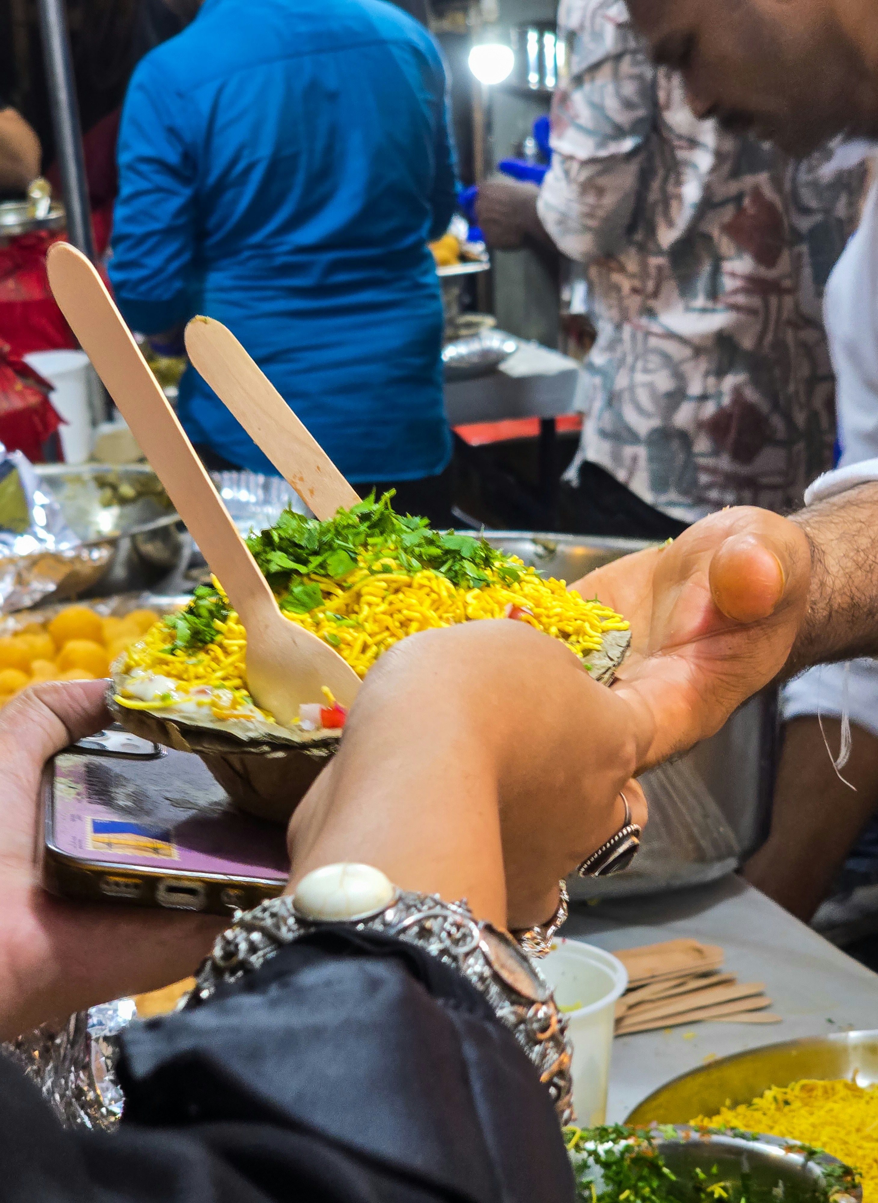 Vibrant street feast: hands and aromatic bowl under market glow