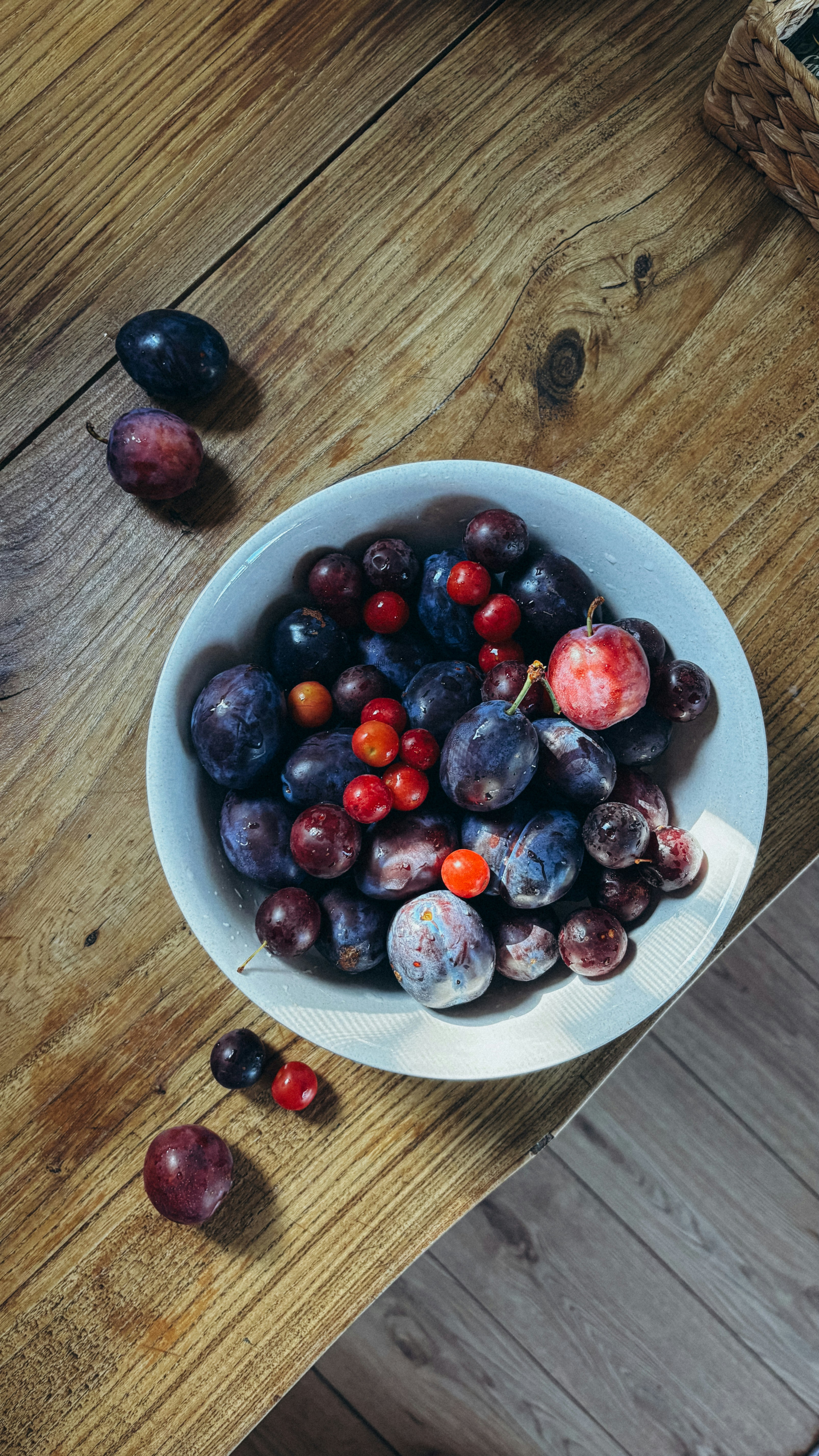 Bowl of berries on a sunlit wooden table