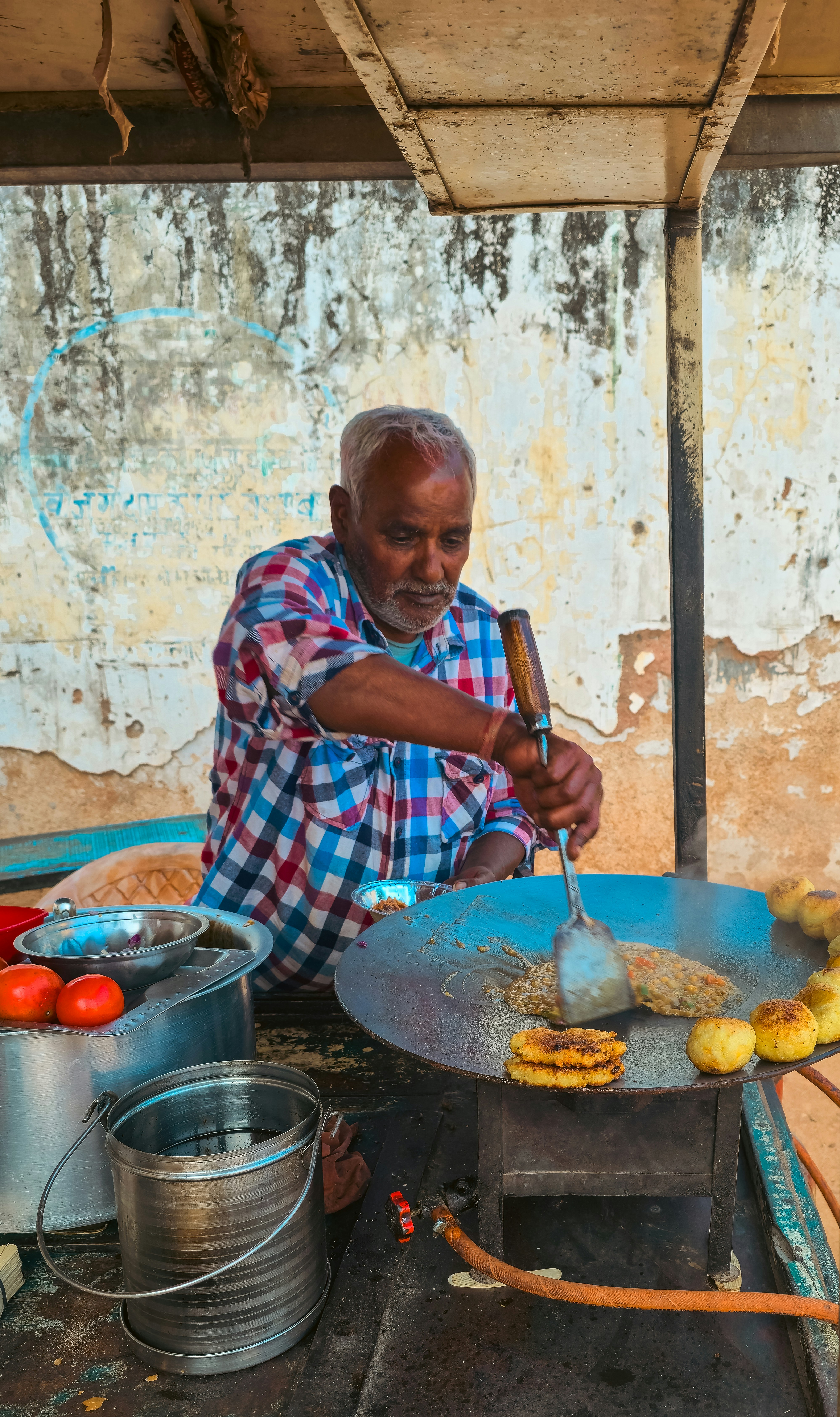 Griddle Craft: A Street Vendor Flips Crispy Corn Cakes Under a Sunlit Canopy