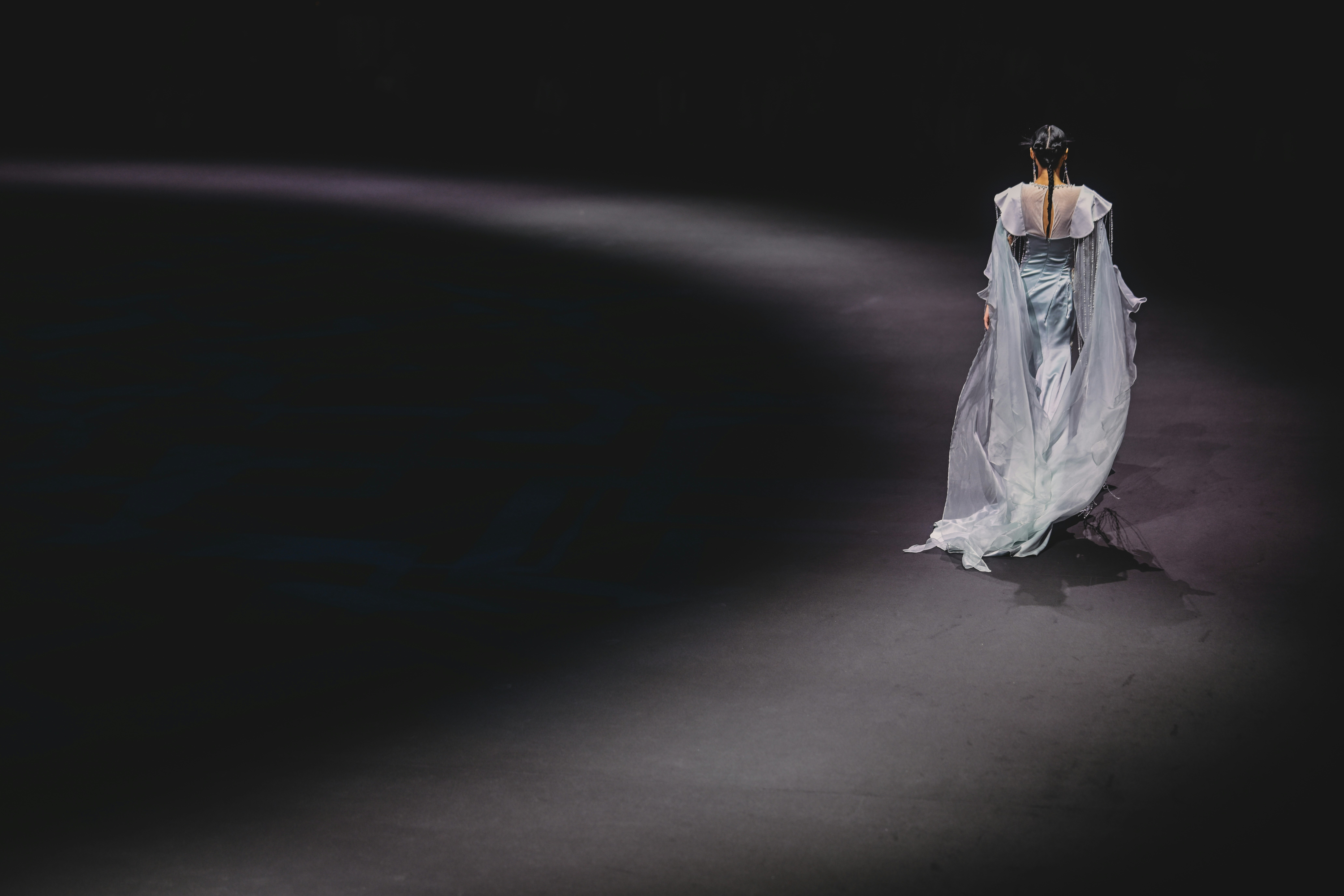 Isolated Silhouette: A Dancer Emerges from the Spotlight Curve