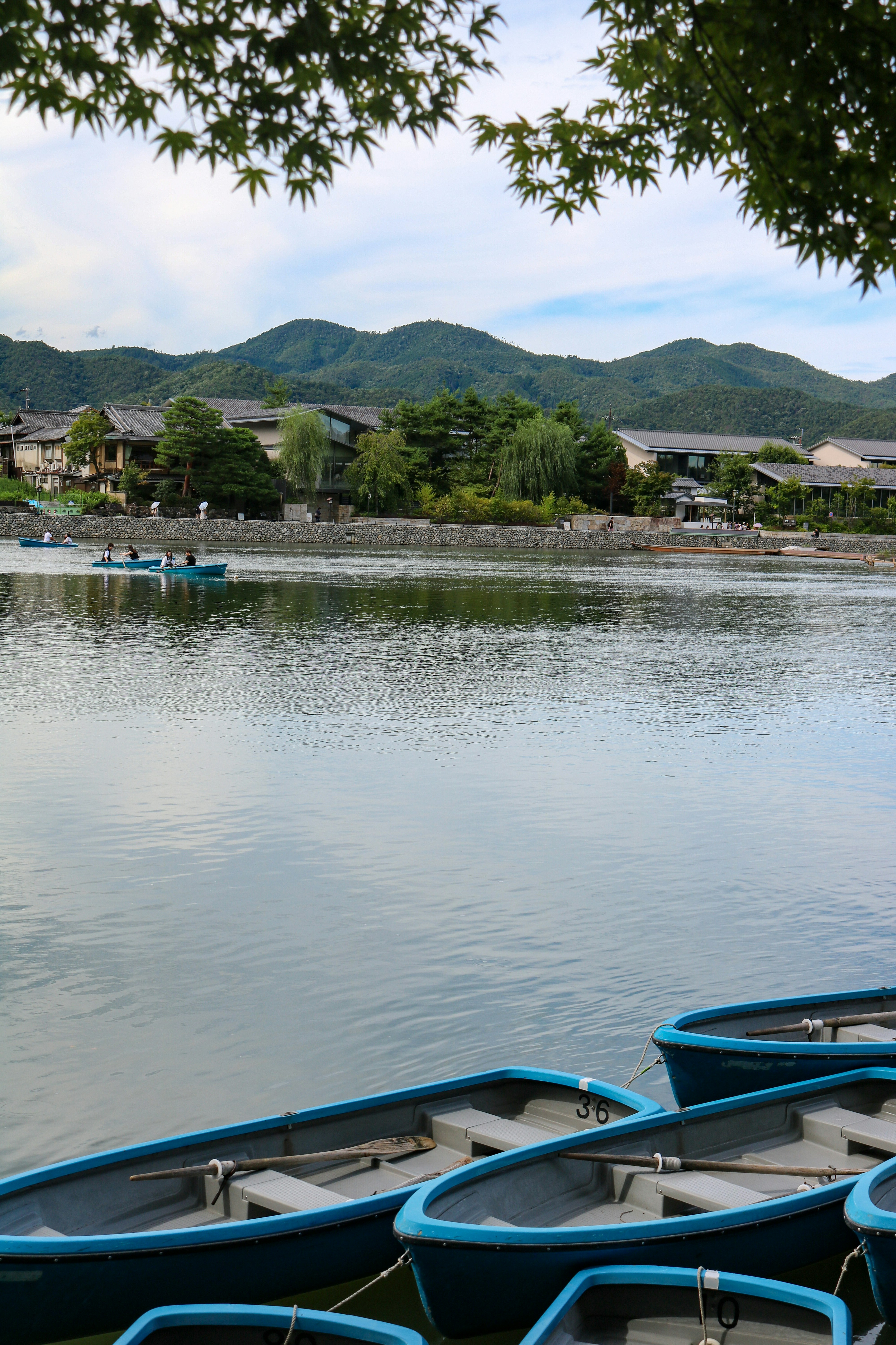 Blue Rowboats Rest Along a Tranquil Lake with Hills in the Background