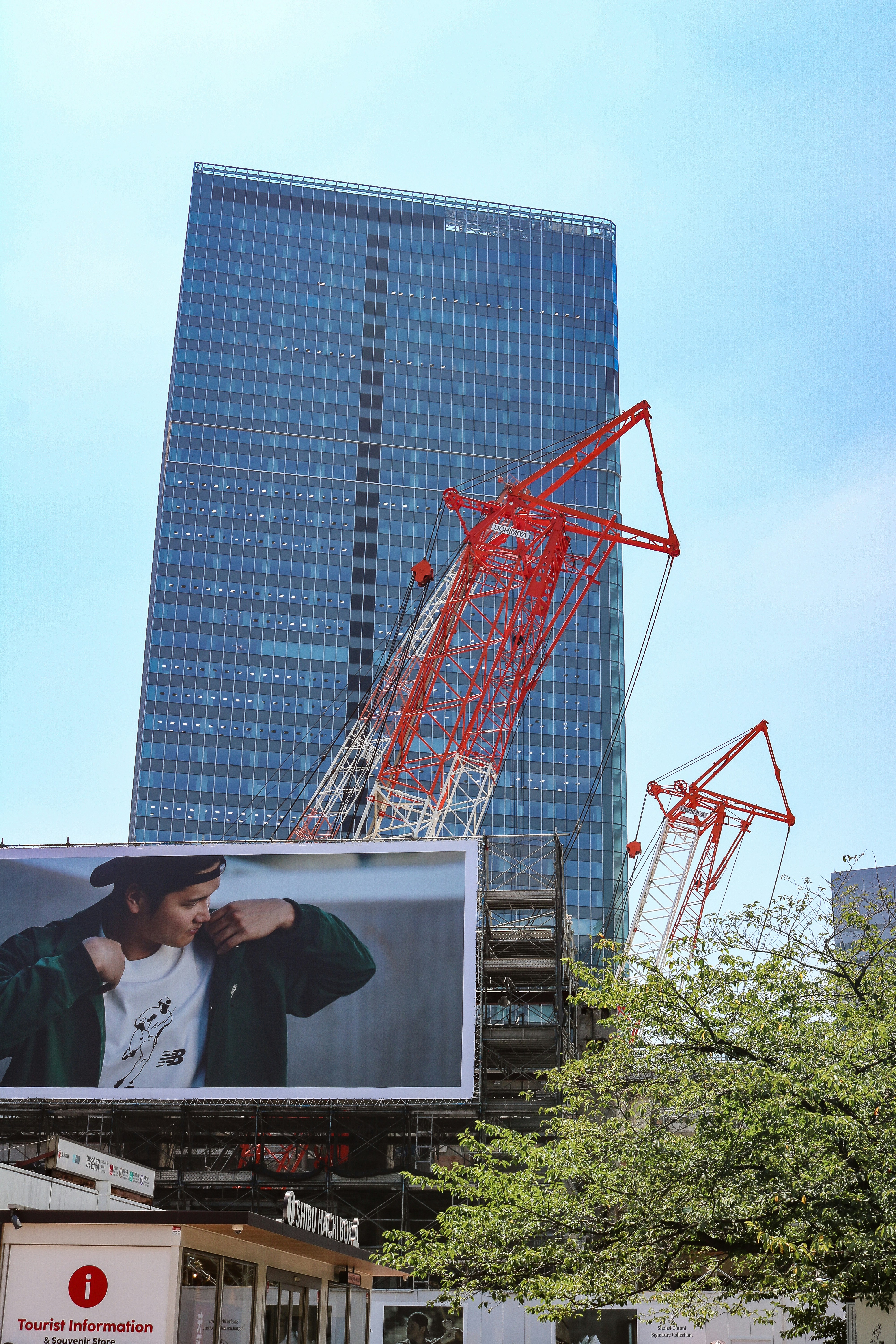 Crane Lattice and Glass Tower Overlooking a Billboard