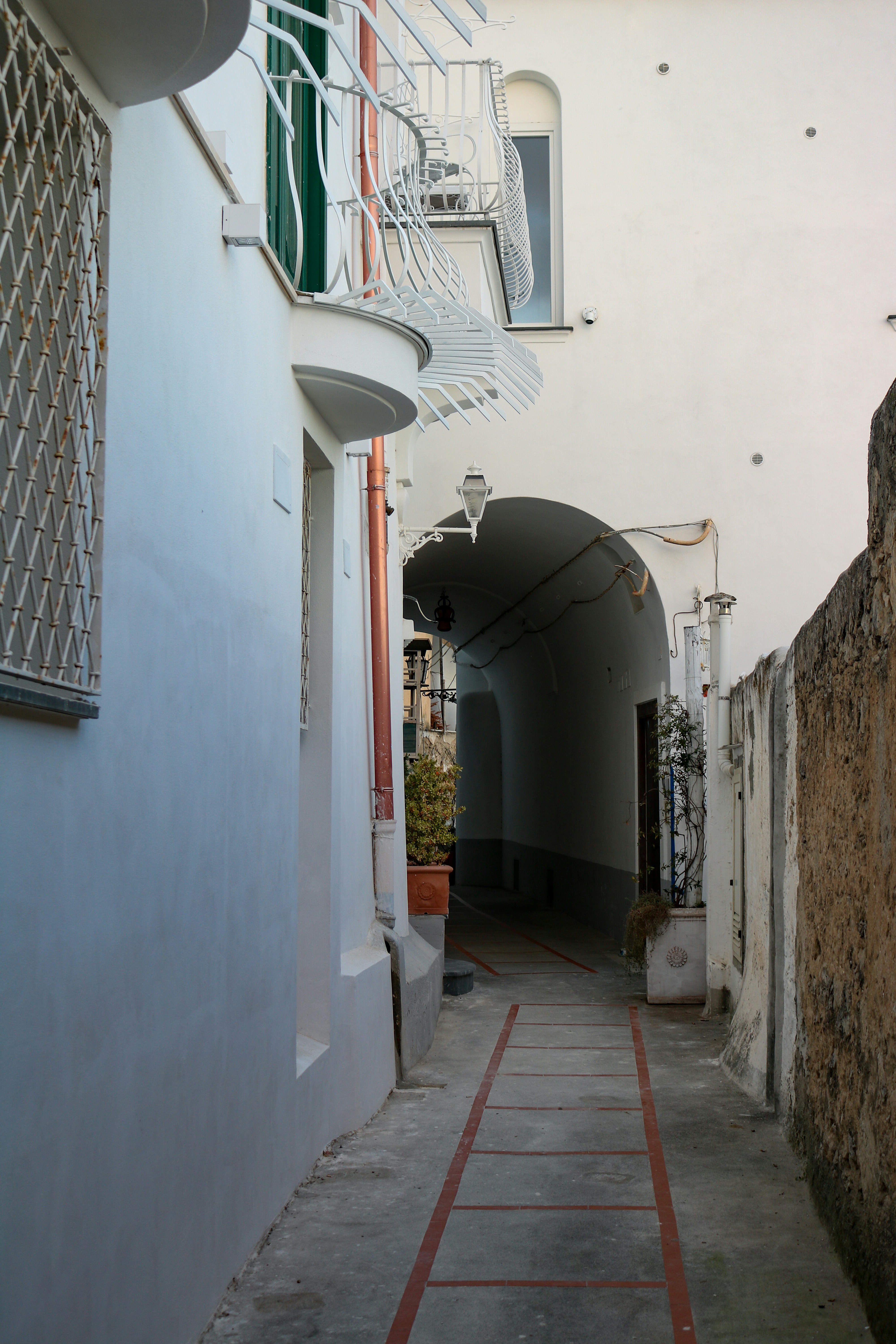 Sunlit Archway Corridor Between Blue and White Walls