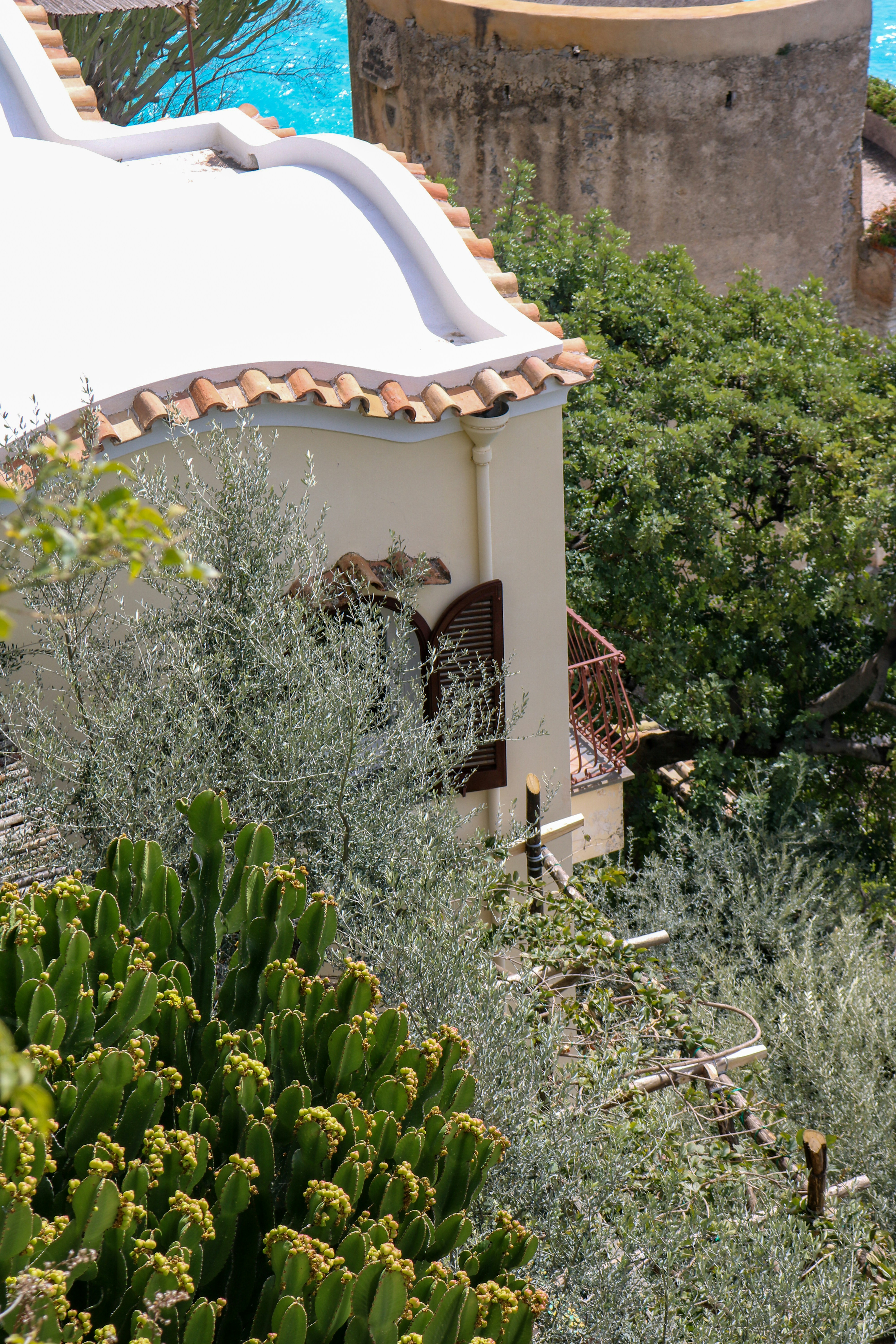 Terraced villa with tiled roof and lush Mediterranean greenery