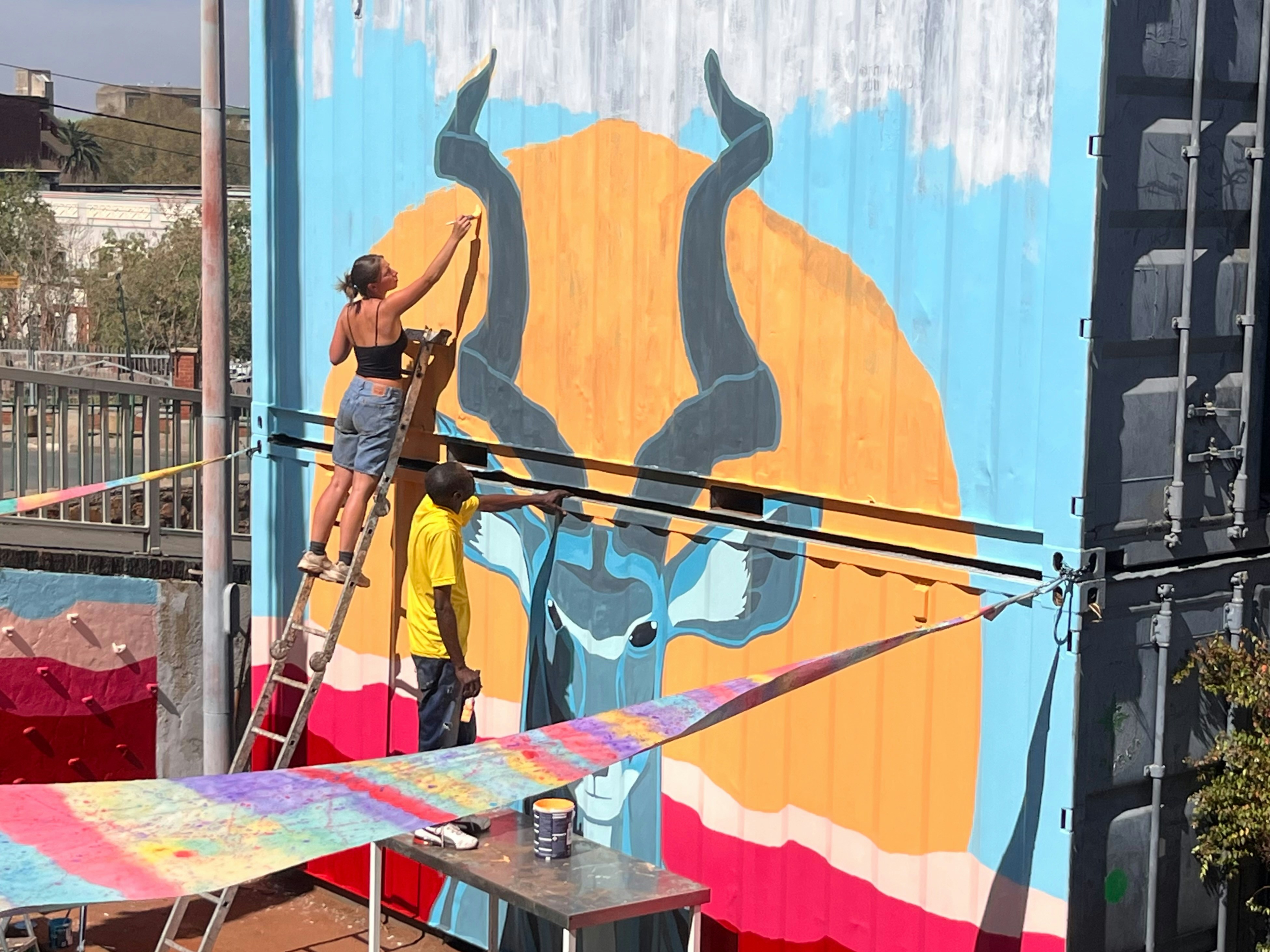 Mural Crew at Work: Colors Meet Steel and Sky
