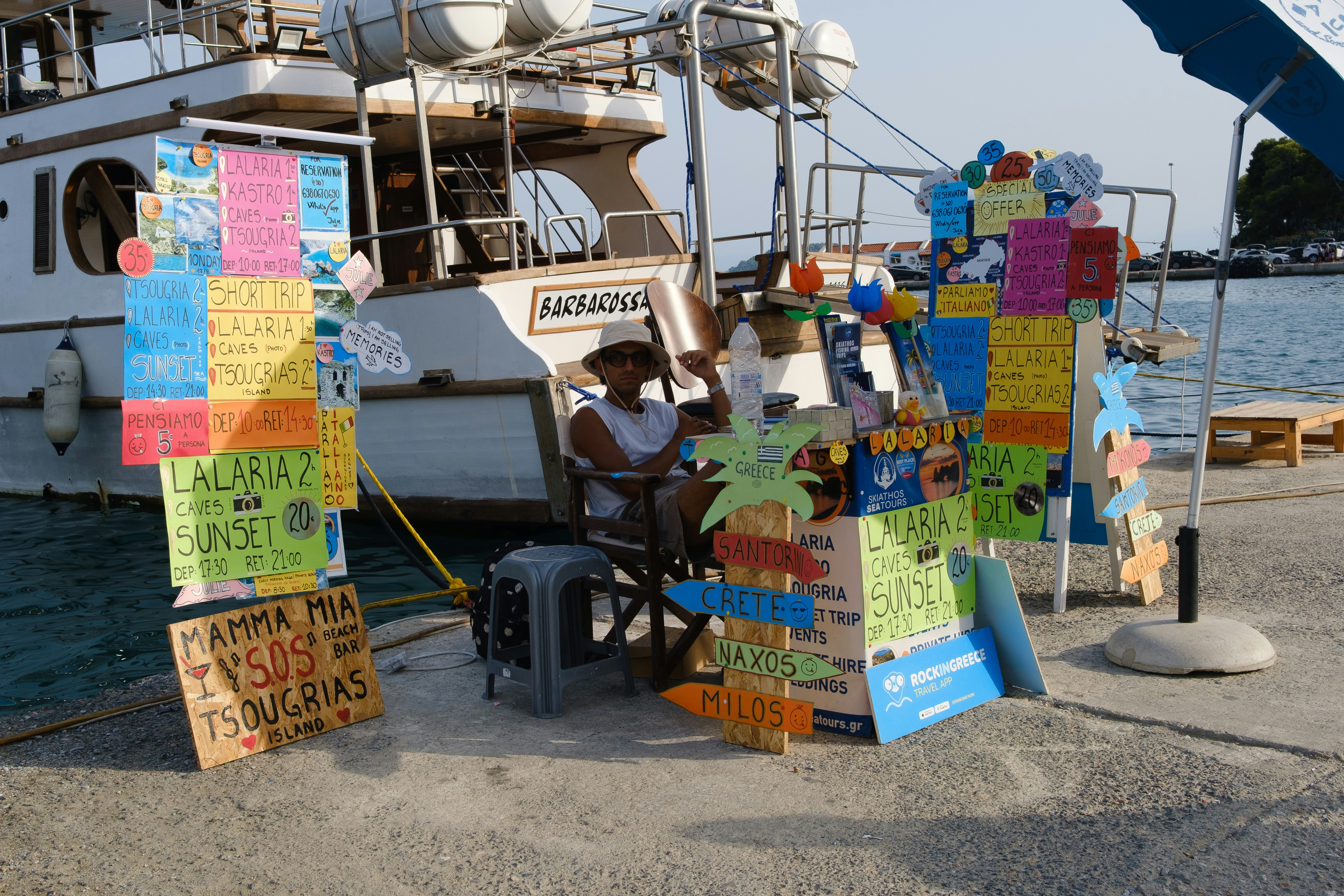 Tied to the Tarp: Colorful Signboard Stand by the Harbor