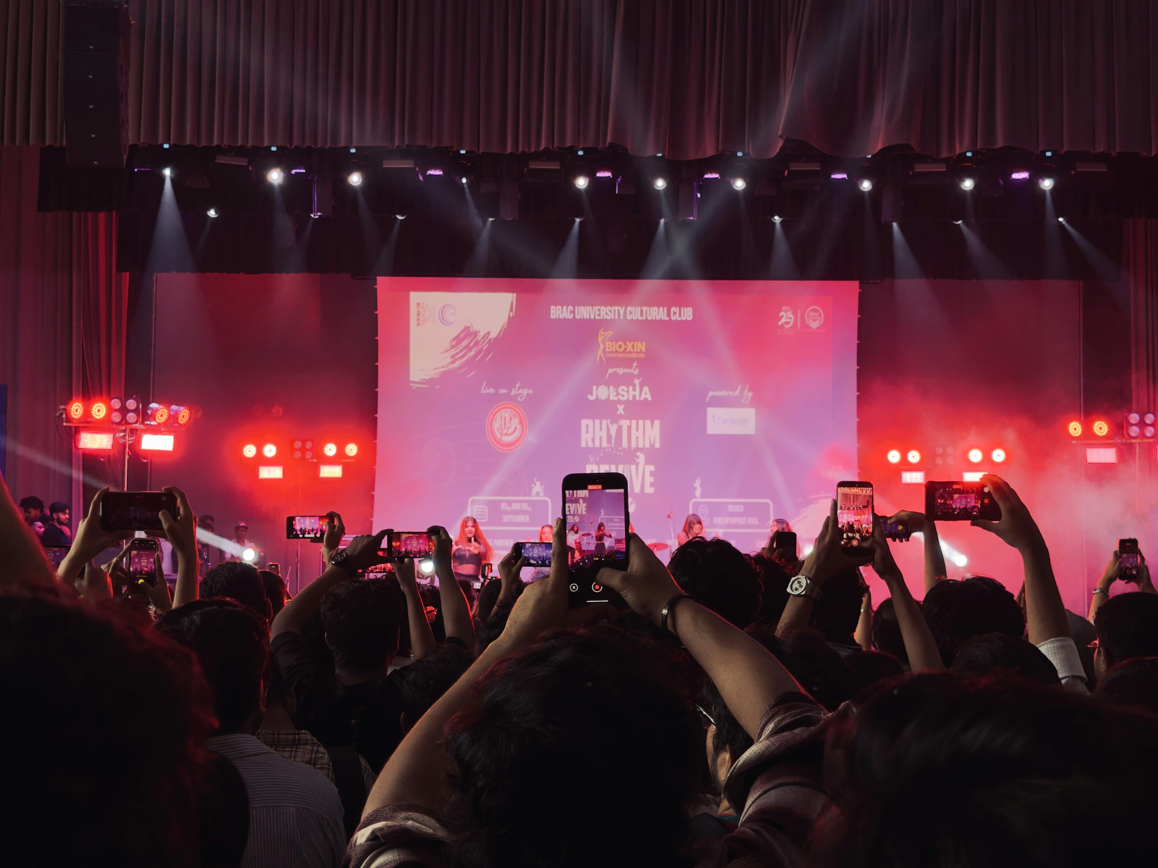 Hands Up for the Spotlight: Crowd Captures the Stage Glow
