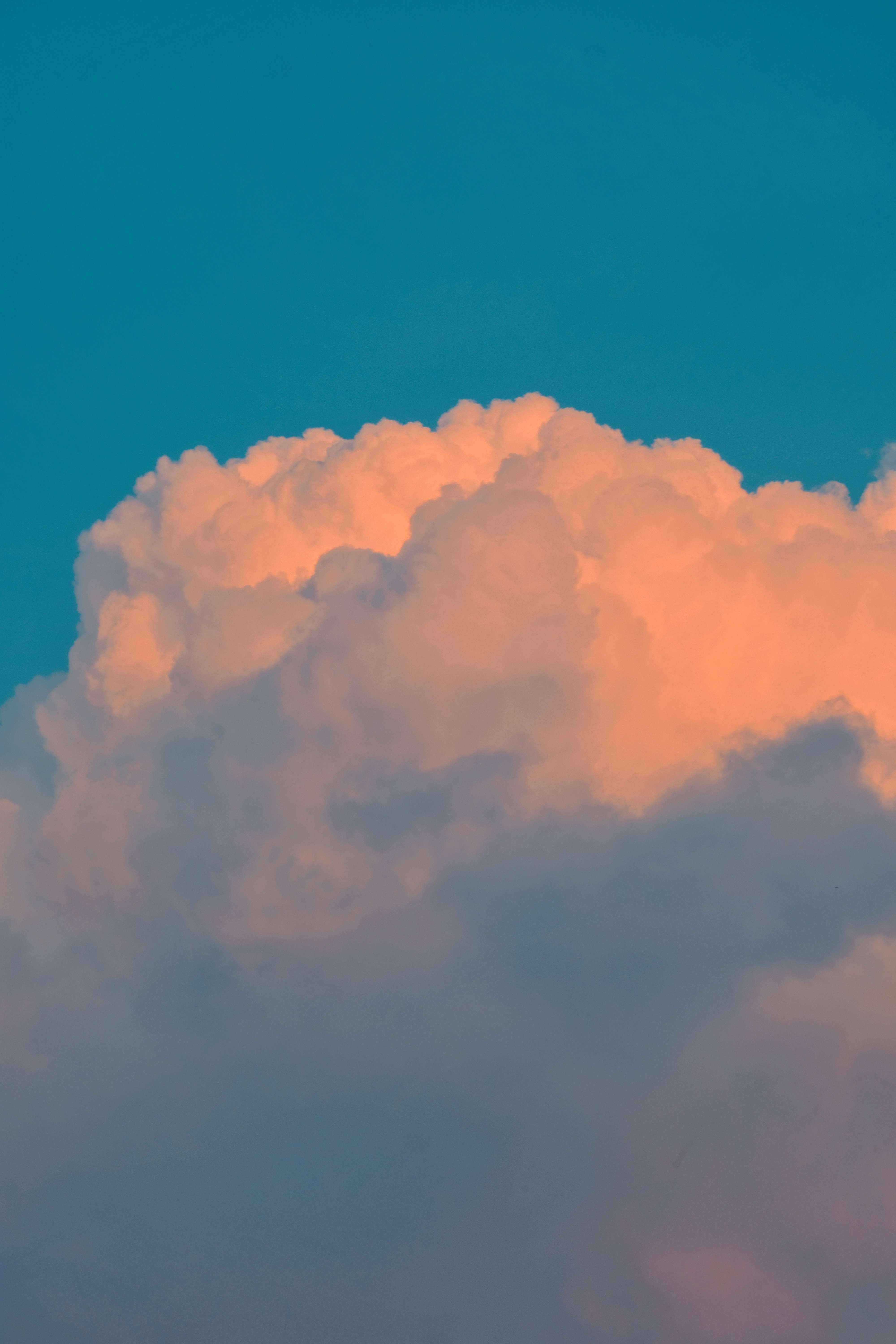 Sunlit summit: a towering cloud crest against a teal sky