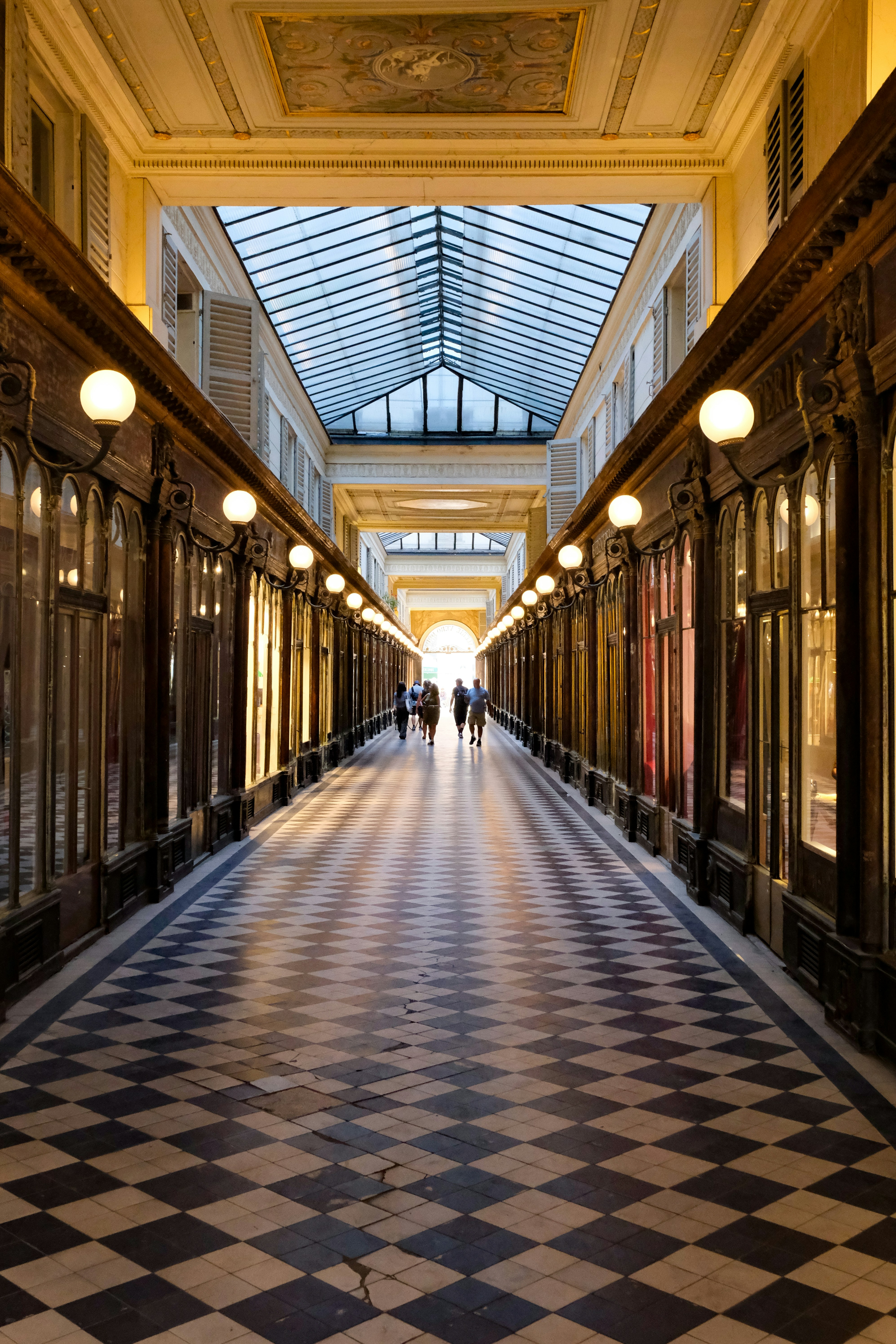 Symmetry Walk: A Lantern-lit Arcade Reaching Toward the Glass Roof