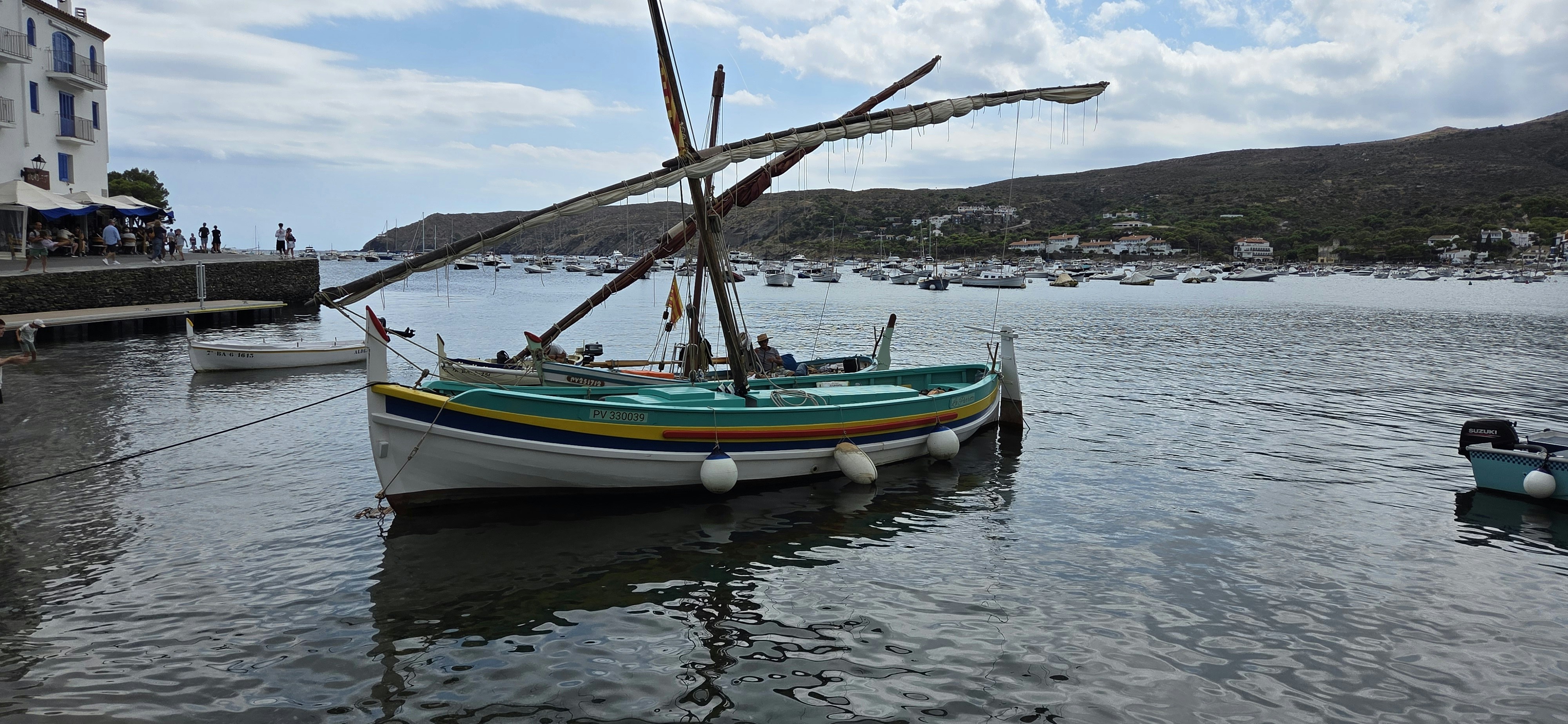Colorful fishing boat anchored in a tranquil harbor at midday