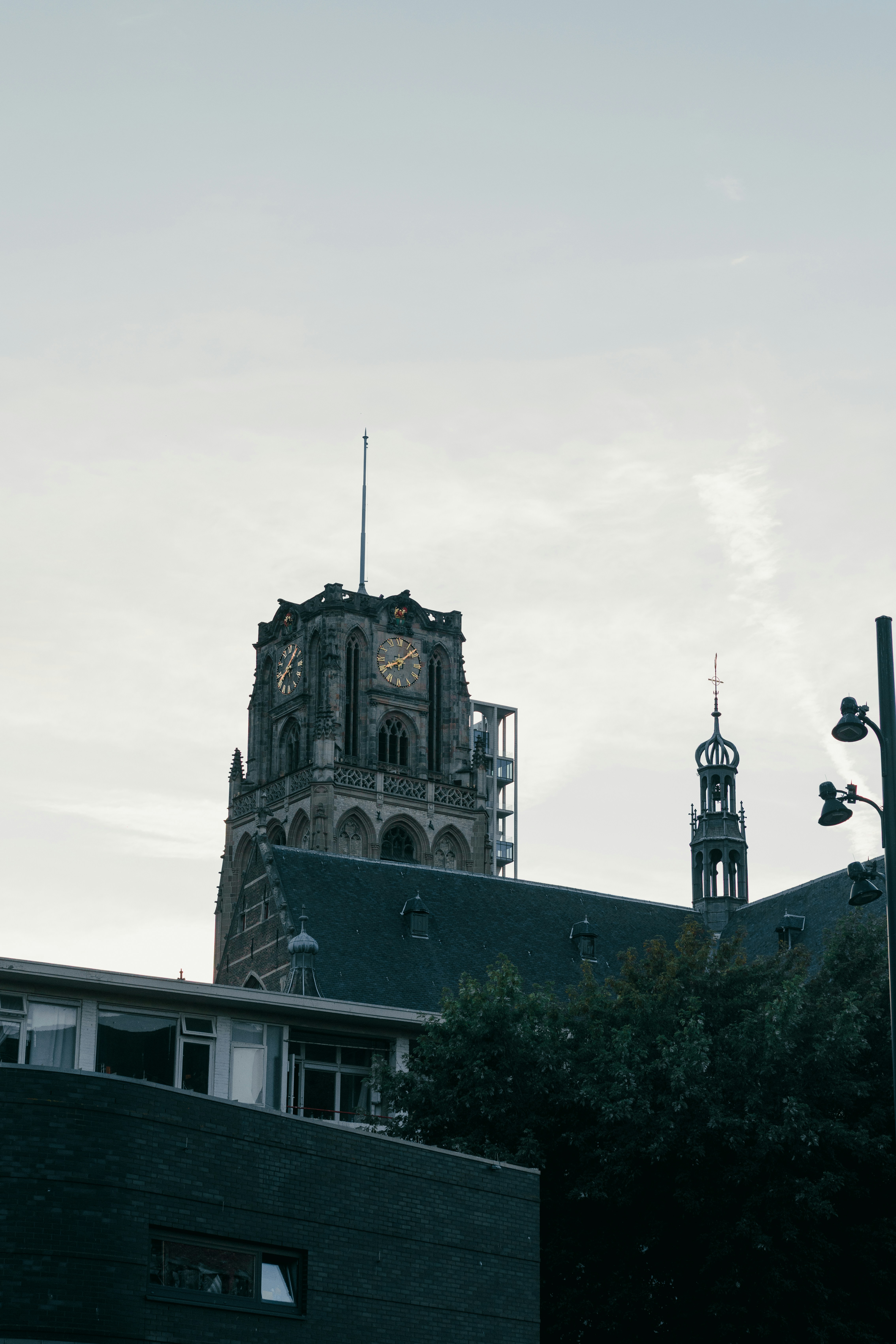 The historic Grote of Sint-Laurenskerk church tower rising above modern buildings in Rotterdam