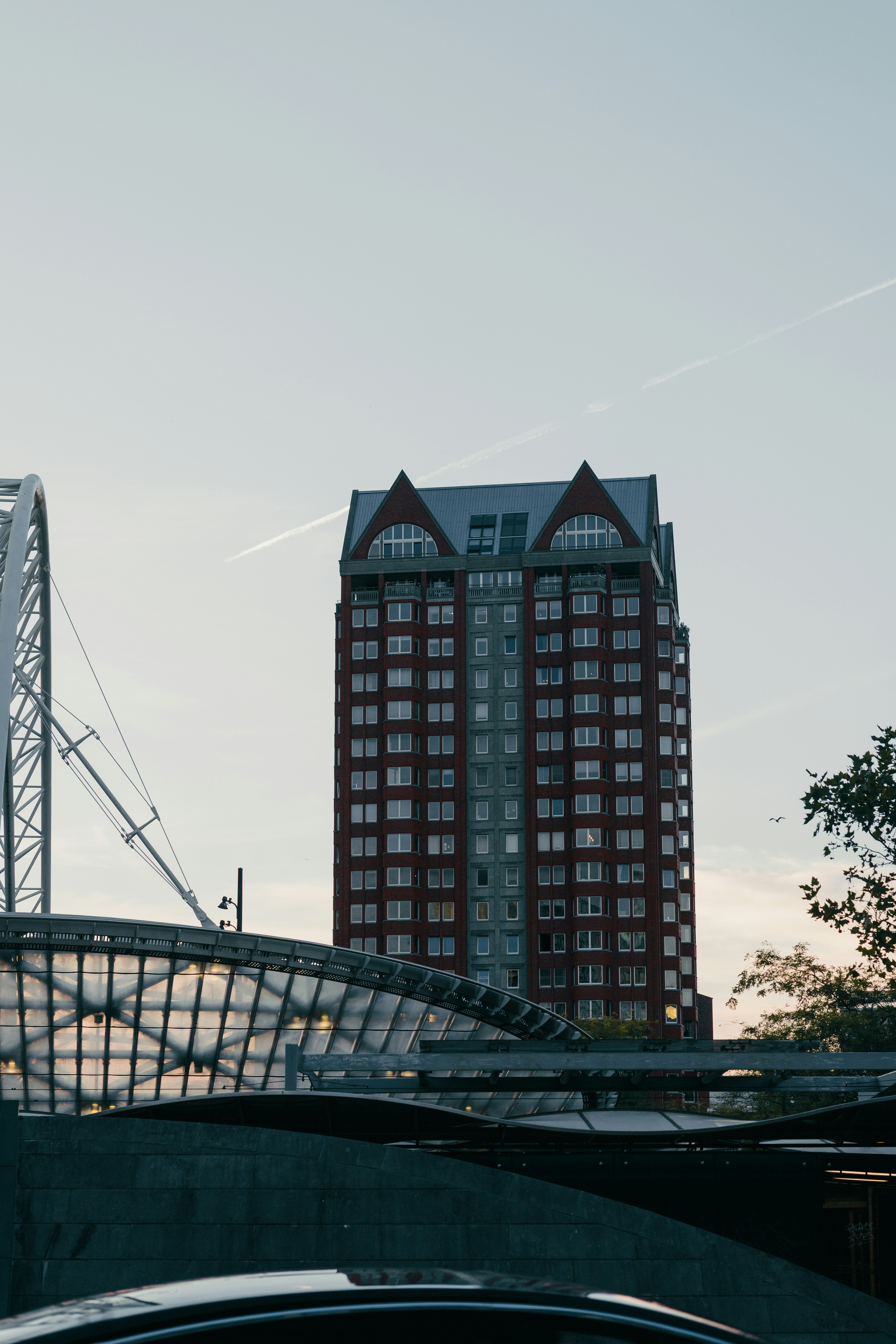 Modern Tower Rising Over a Curved Metal Bridge