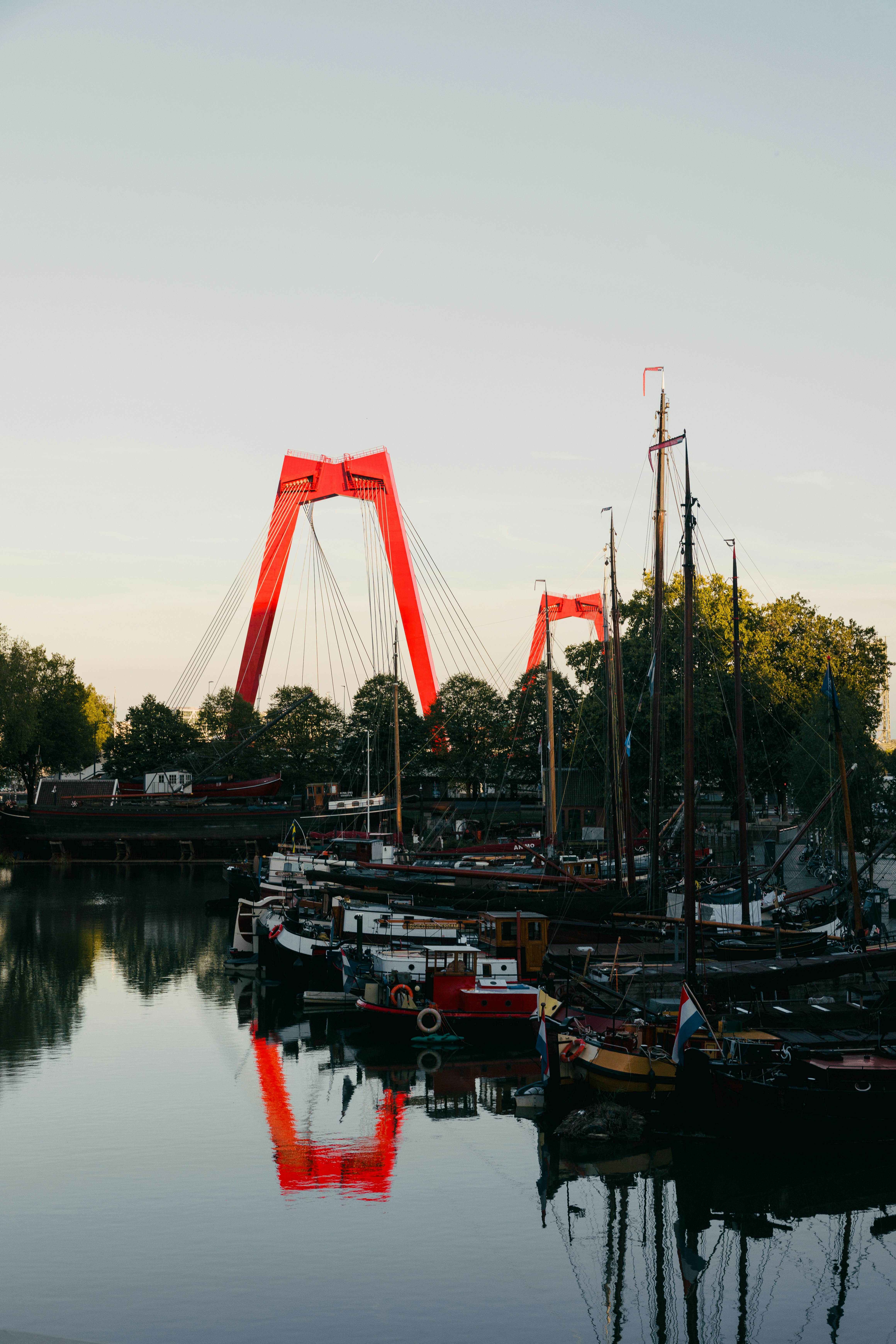 Red Arch Reflections: Boats Rest by the Dusk-Washed Marina
