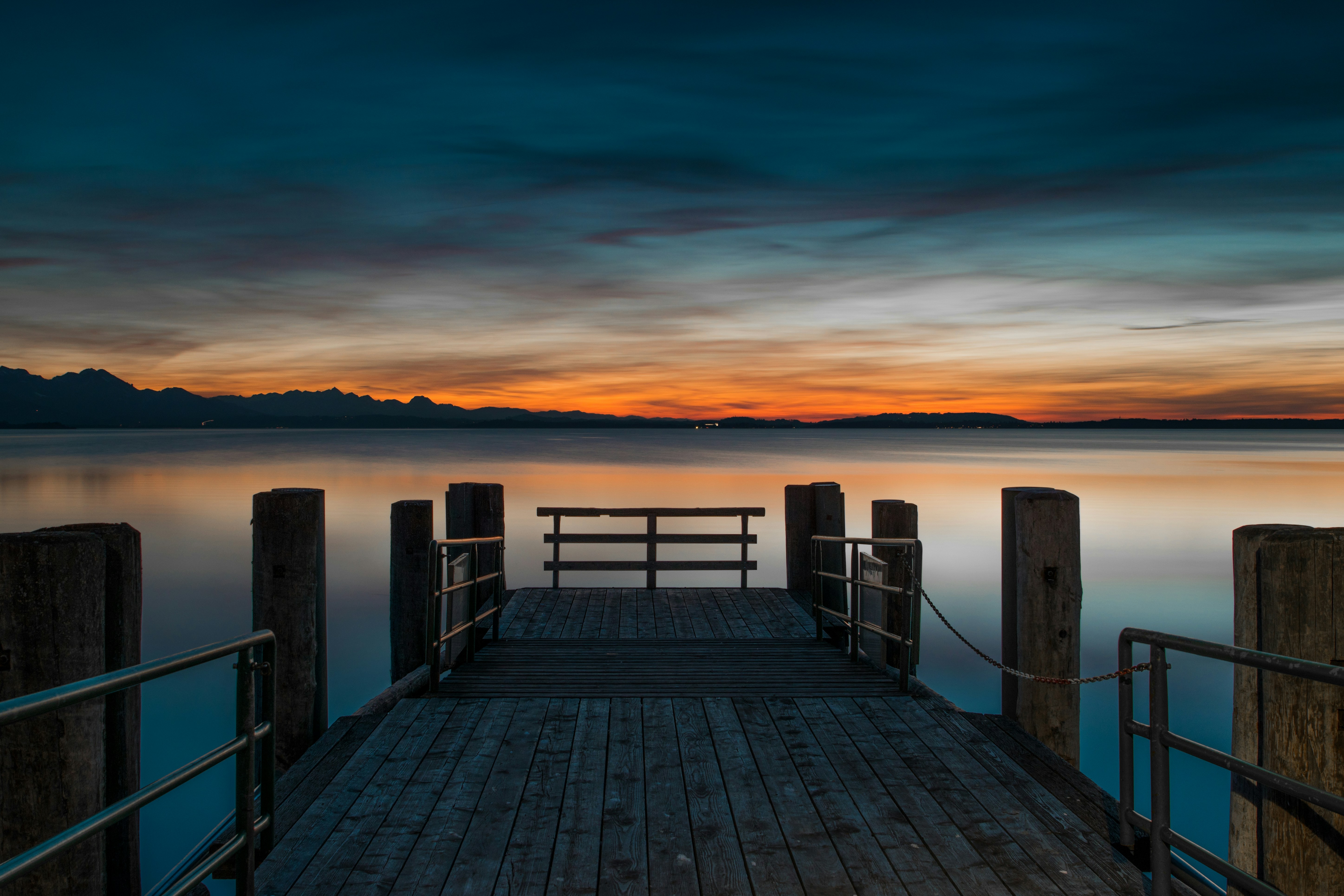 Quiet Pier at Dusk: A Long Wood Causeway Reaching Toward a Velvet Horizon