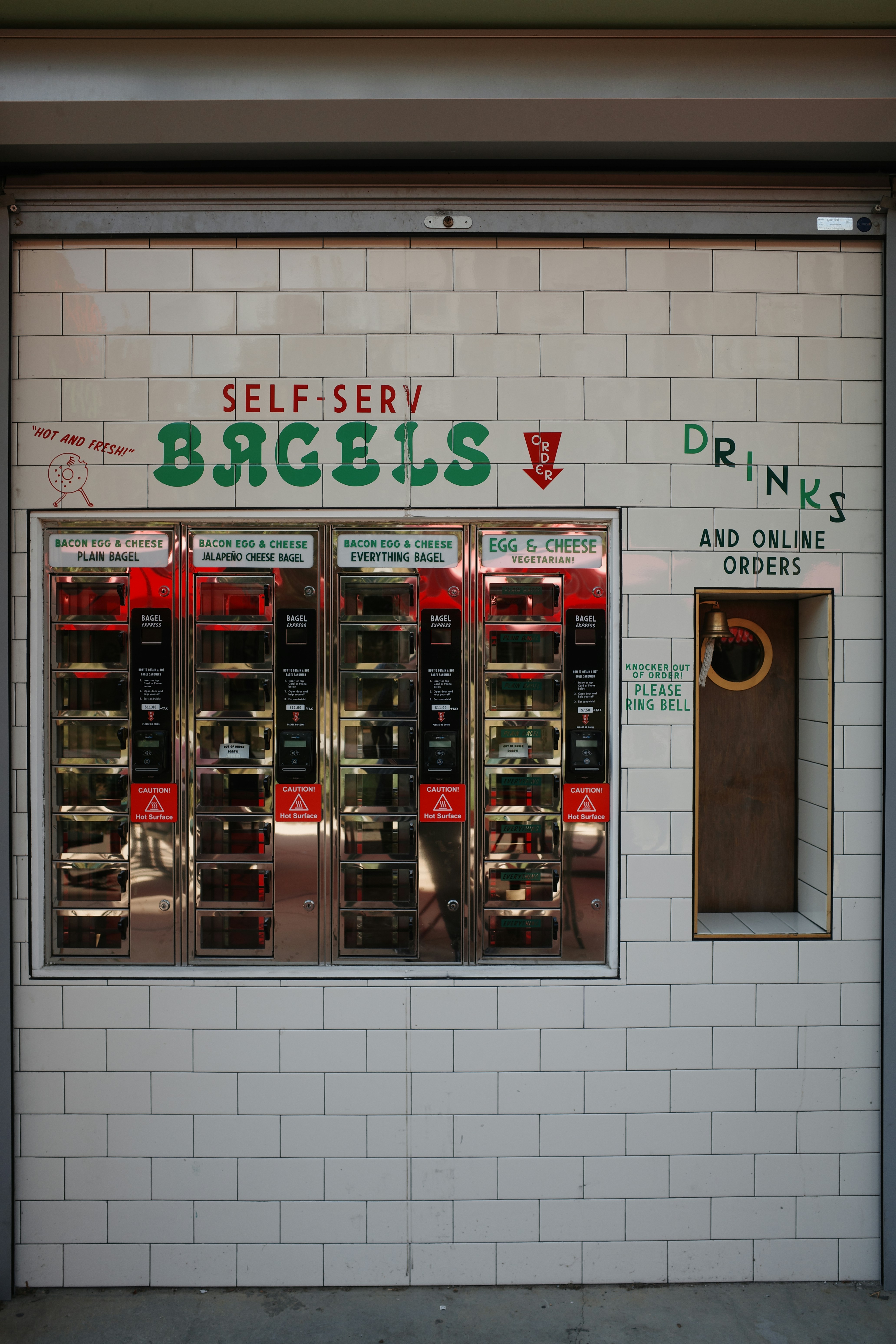 Vending Vistas: Bagel Vending Machines Along a Tiled Street Wall