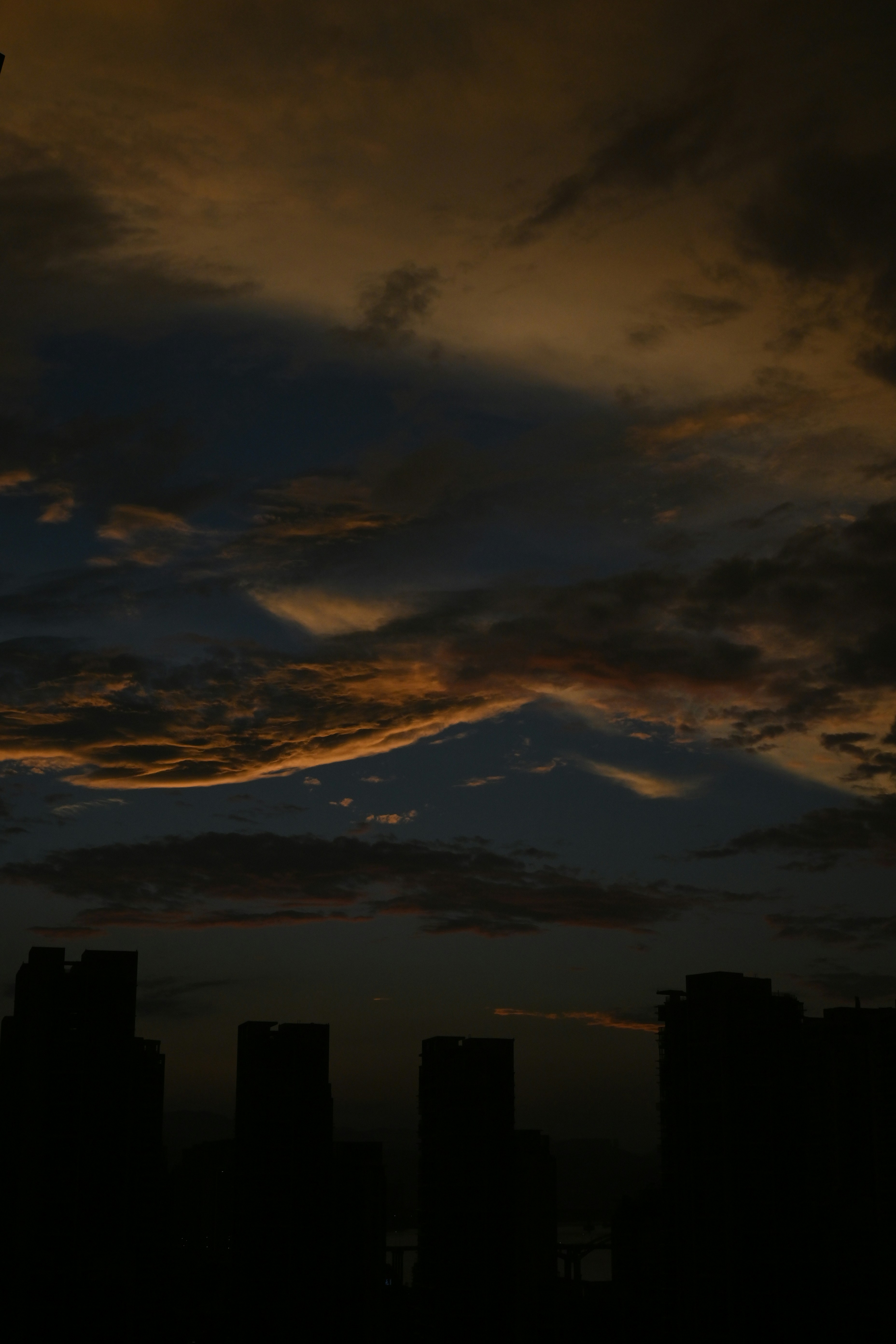  silhouettes at dusk: city skyline beneath a fiery sky