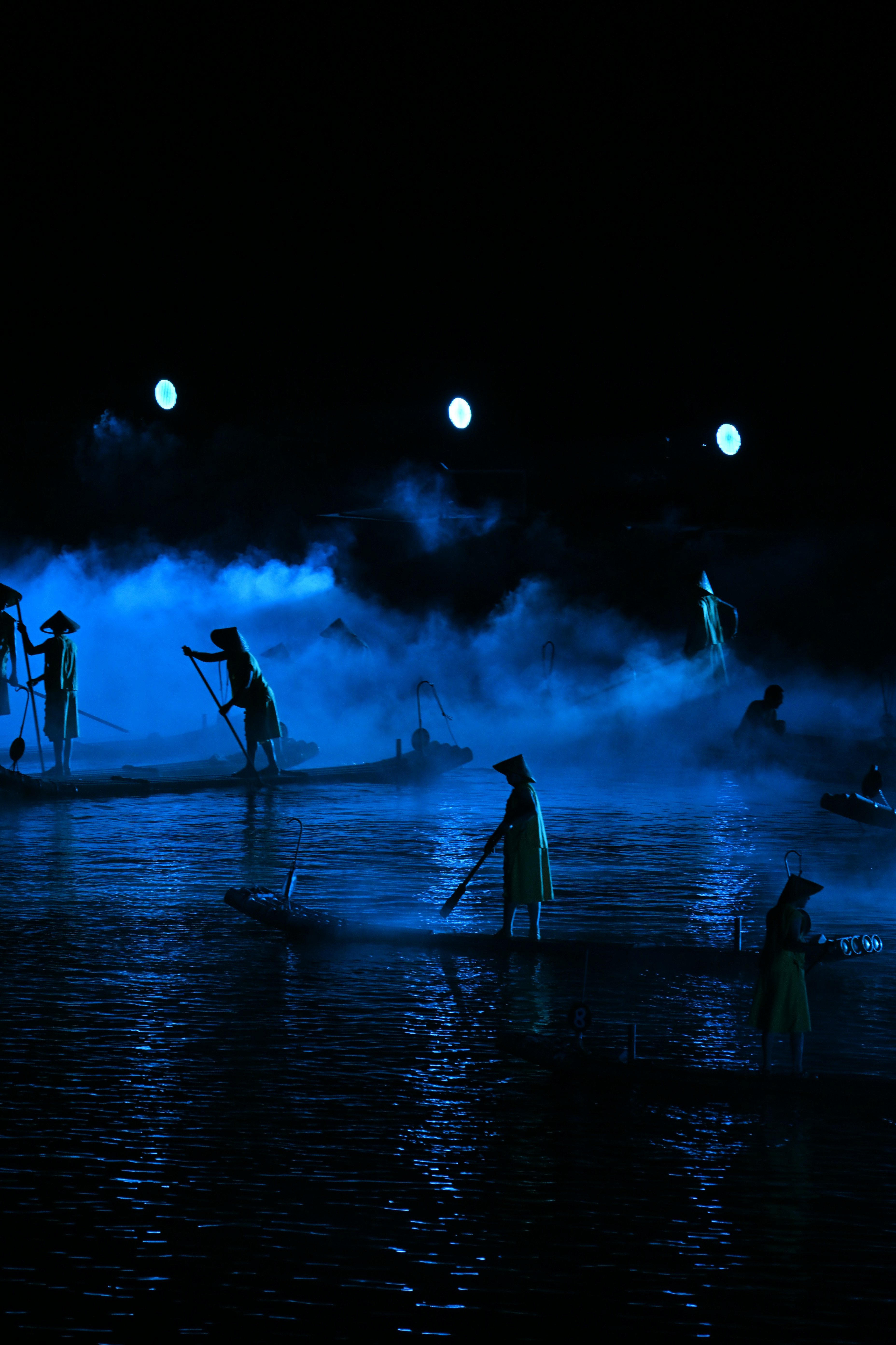 Blue Dawn on the River: Silhouetted Boatmen in Mist