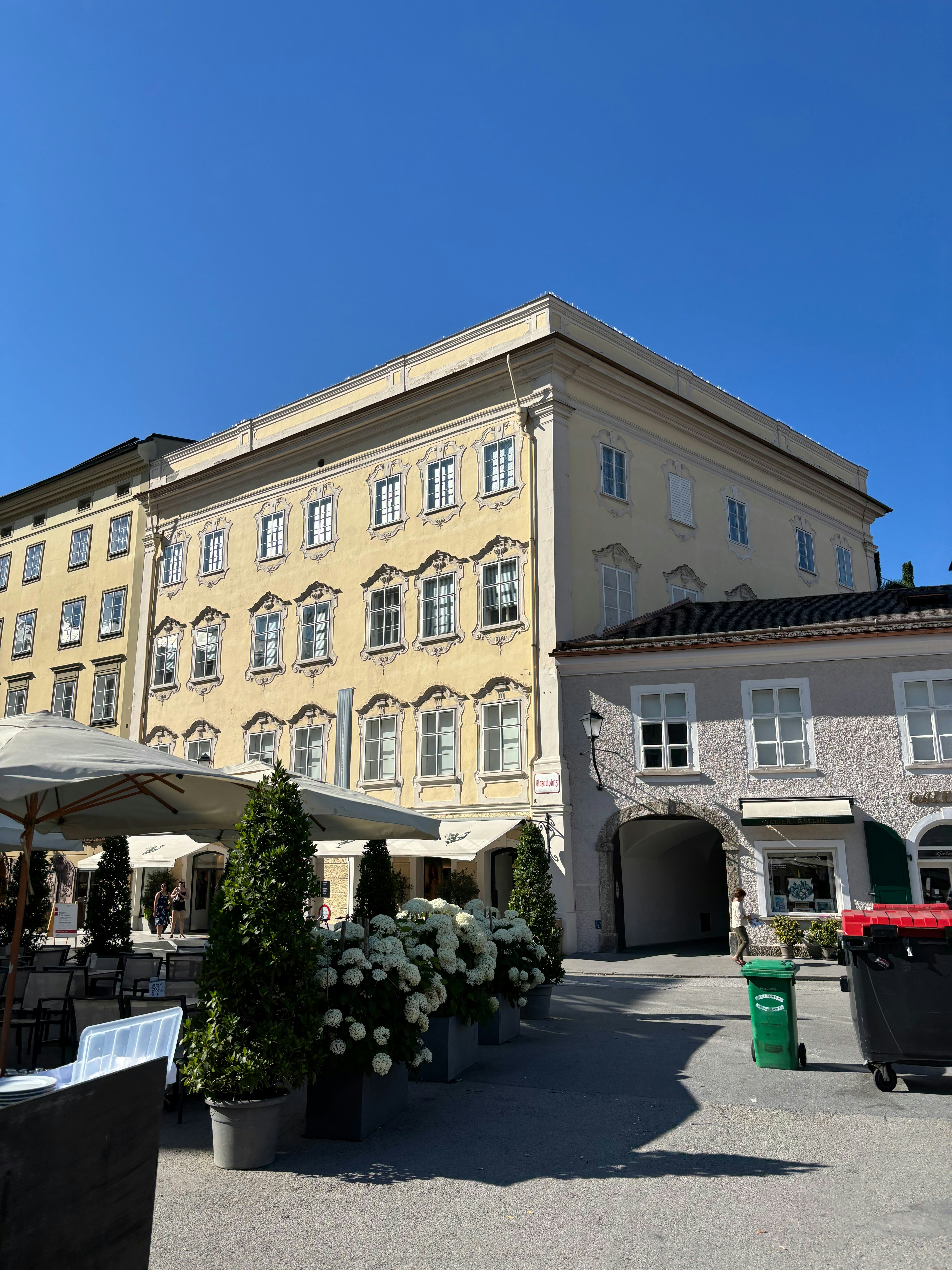 Sunlit European Facade: Heritage Building with Outdoor Café
