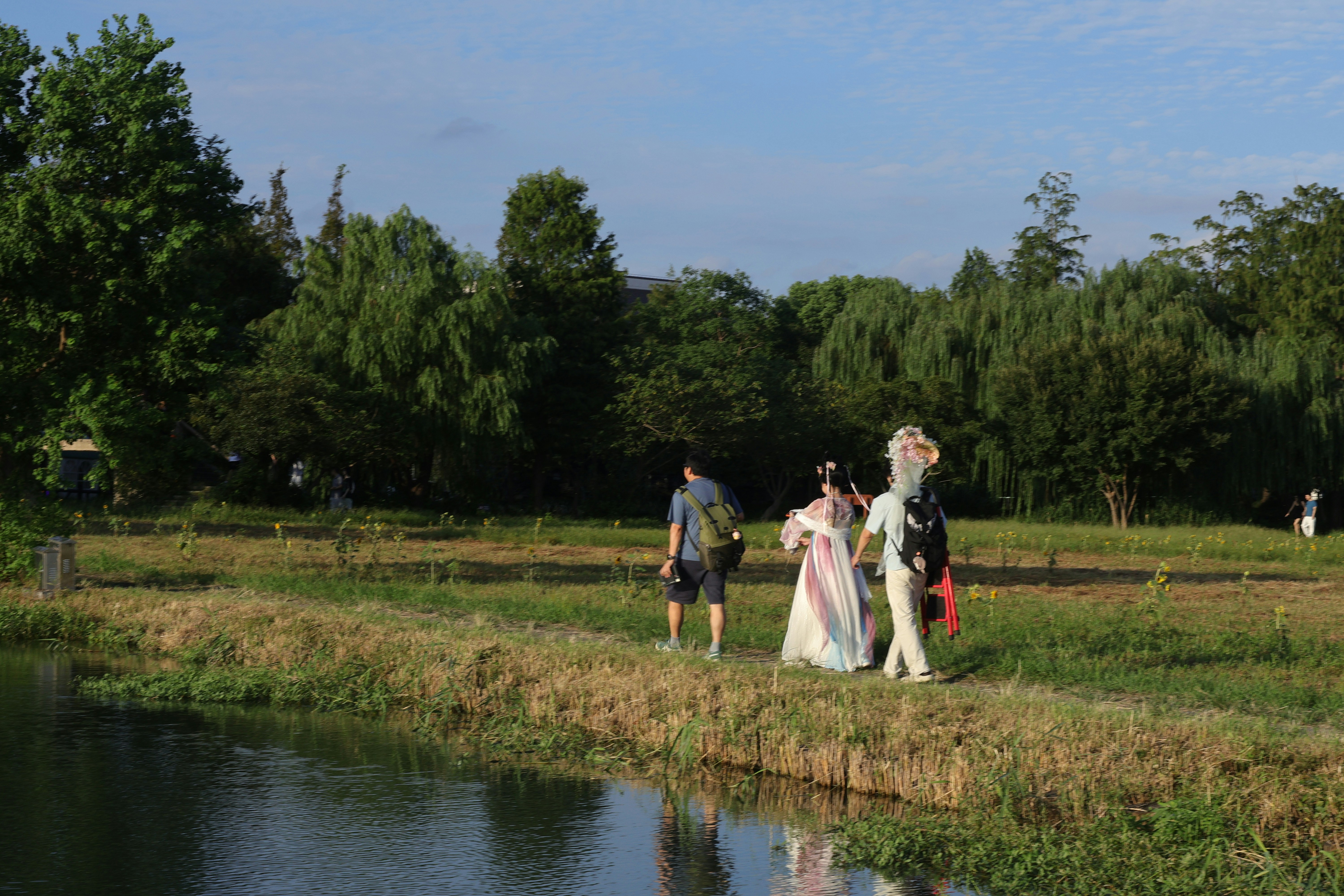 Wedding procession along a sunlit riverside
