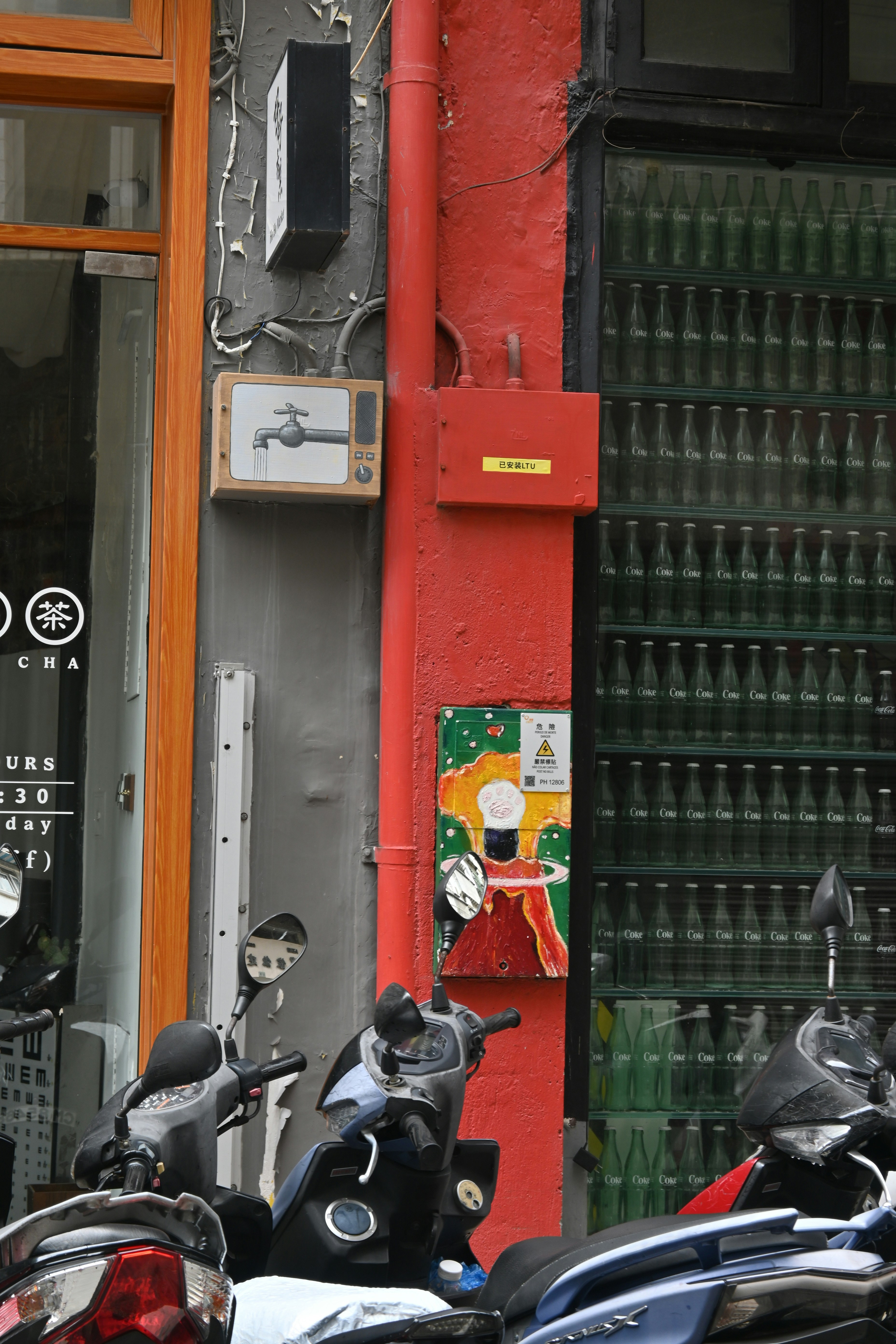 Red Facade, Green Glass, and a Row of Scooters at a Busy Street Corner