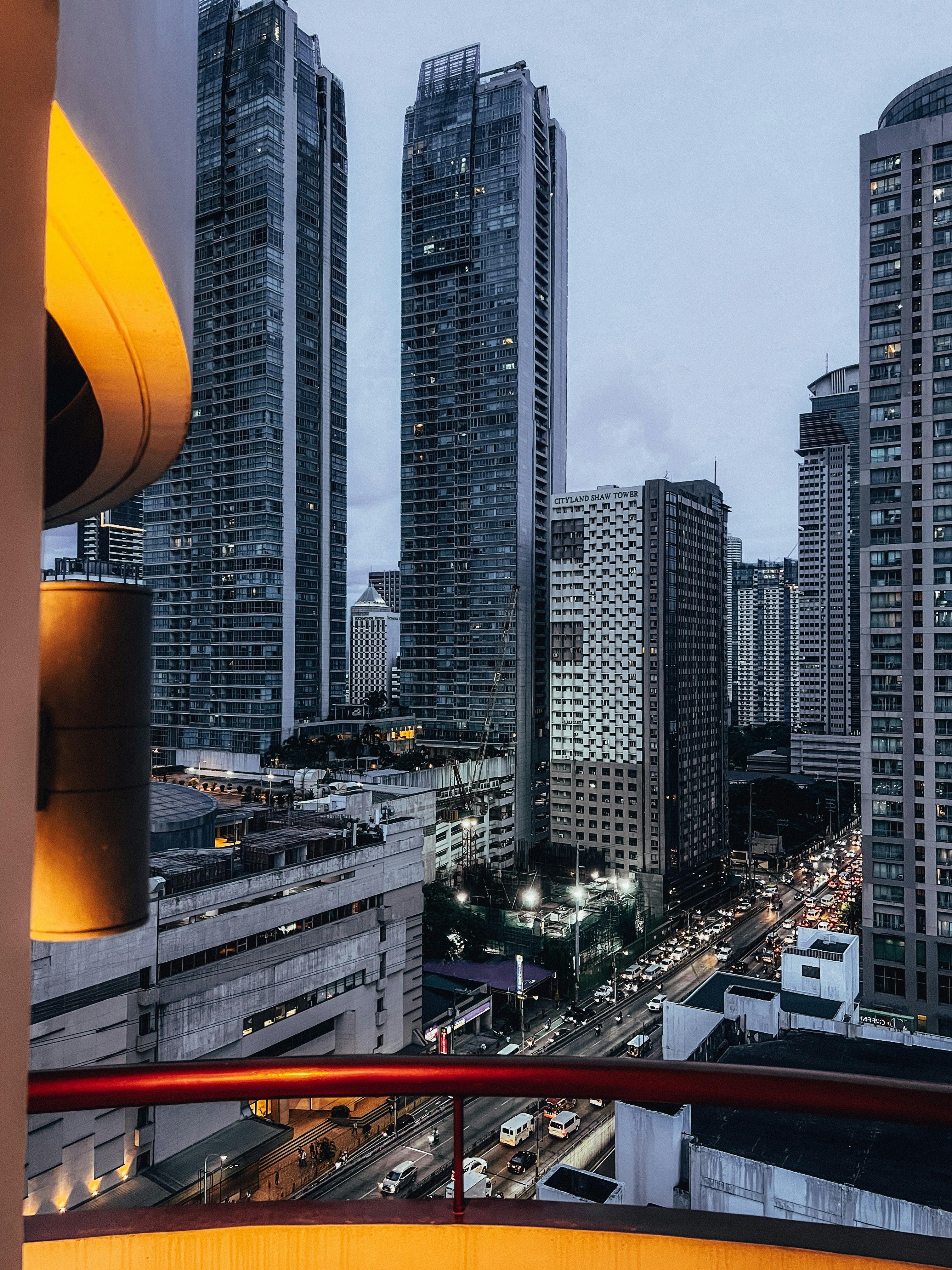 Urban Canyon at Dusk: Towers, Traffic, and Neon Rail