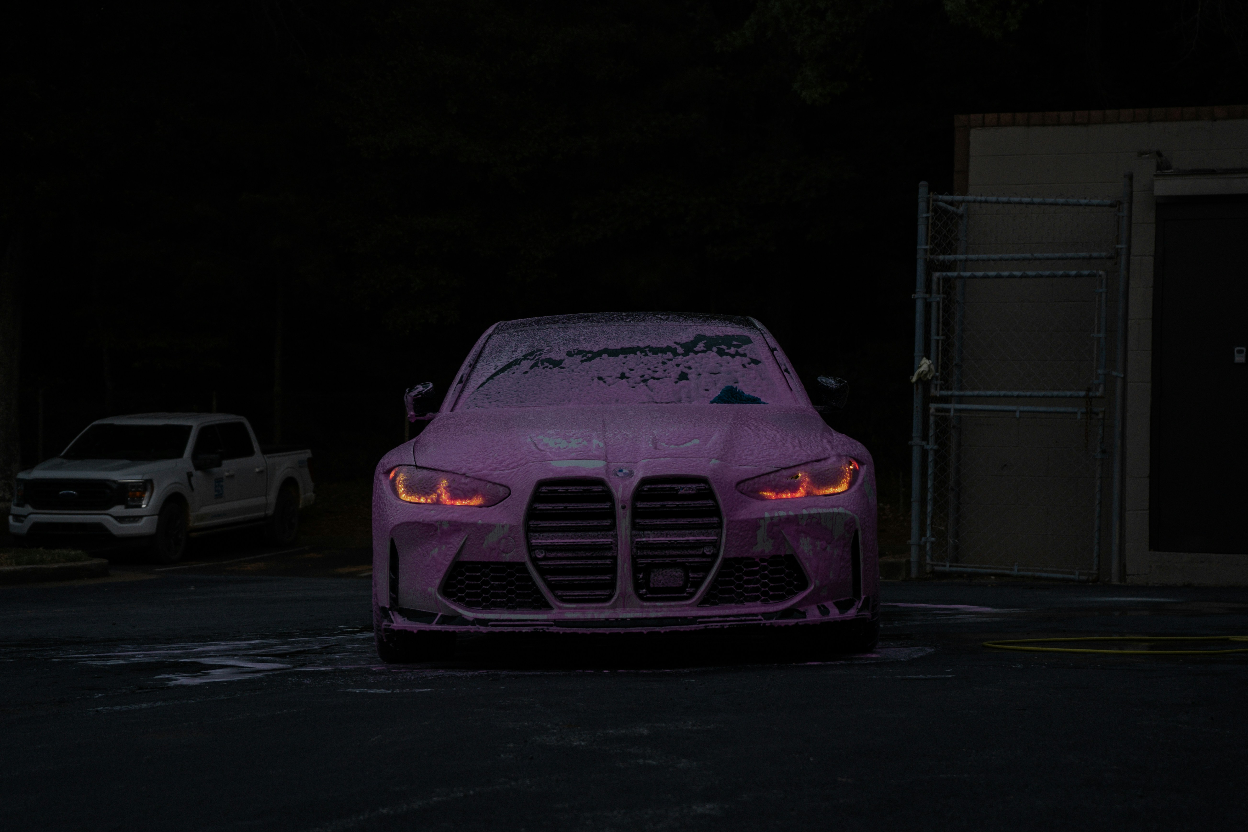Low-Light Chrome: A Neon-Sheen BMW Stares from the Shadows