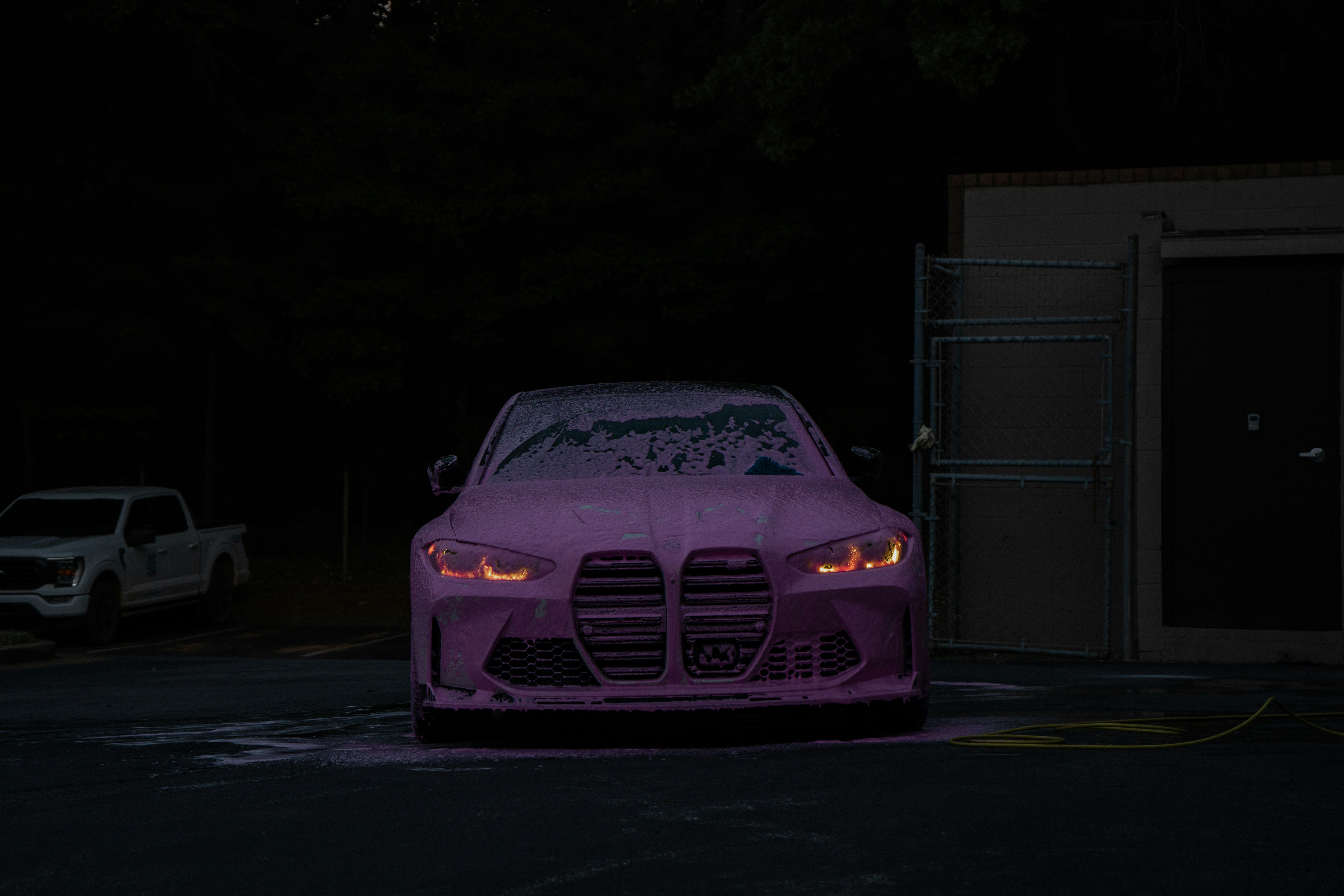 Midnight Velocity: Front View of a Darkened BMW with Neon-tinged Gleam