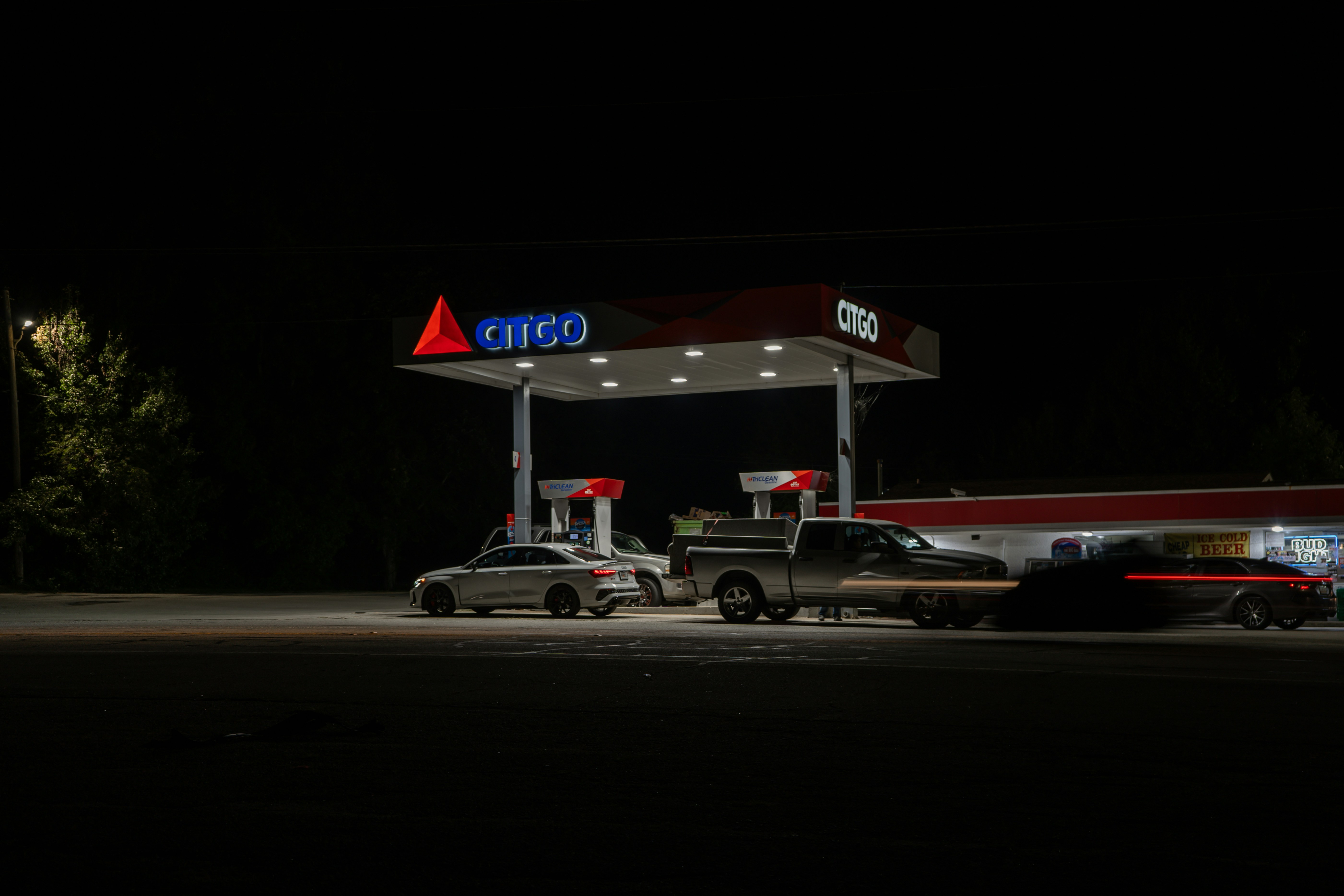 Nighttime Citgo Stop: Dimly Lit Pumps and Moving Tail Lights