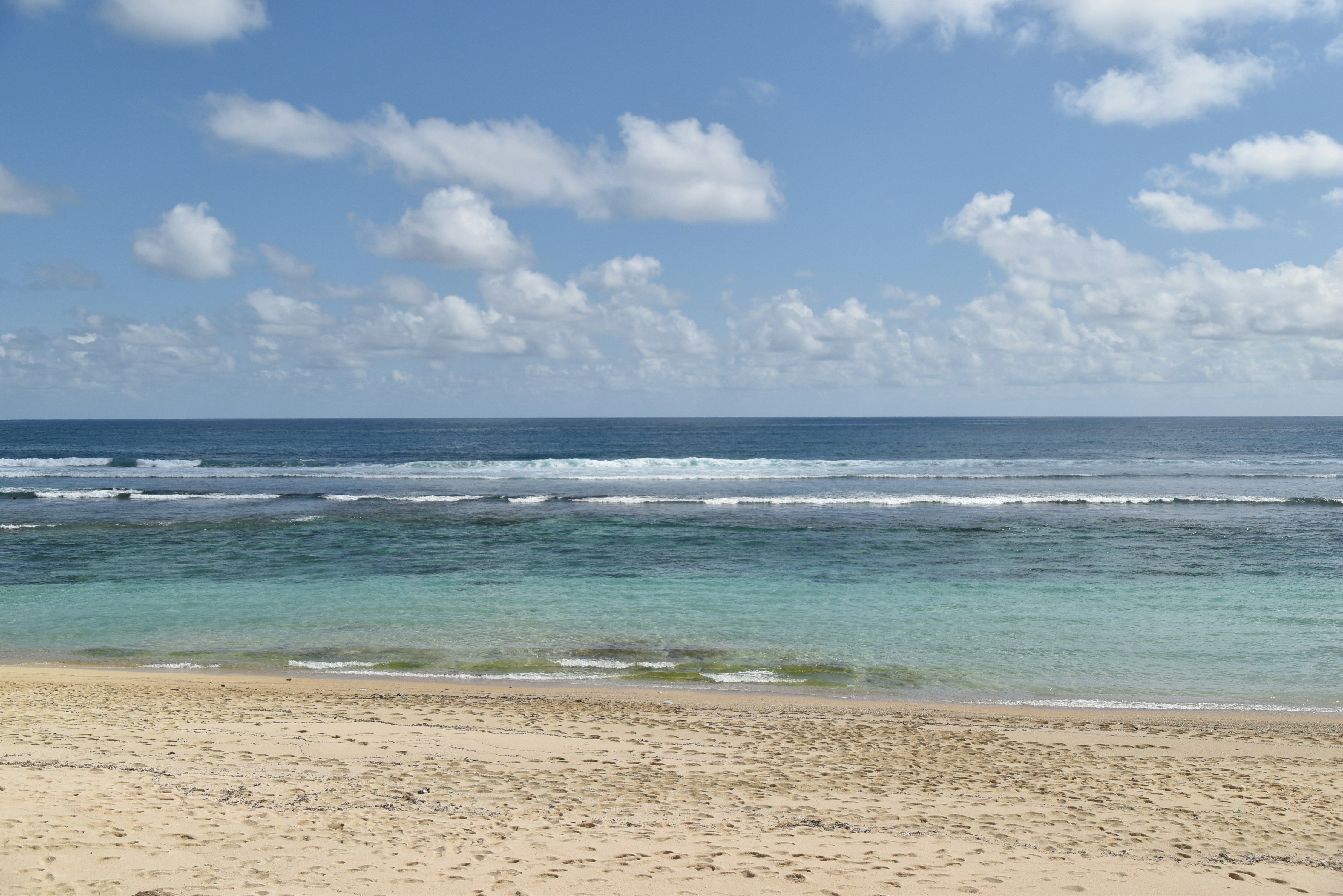 Azure Horizon: Quiet Beach beneath a Capricious Sky