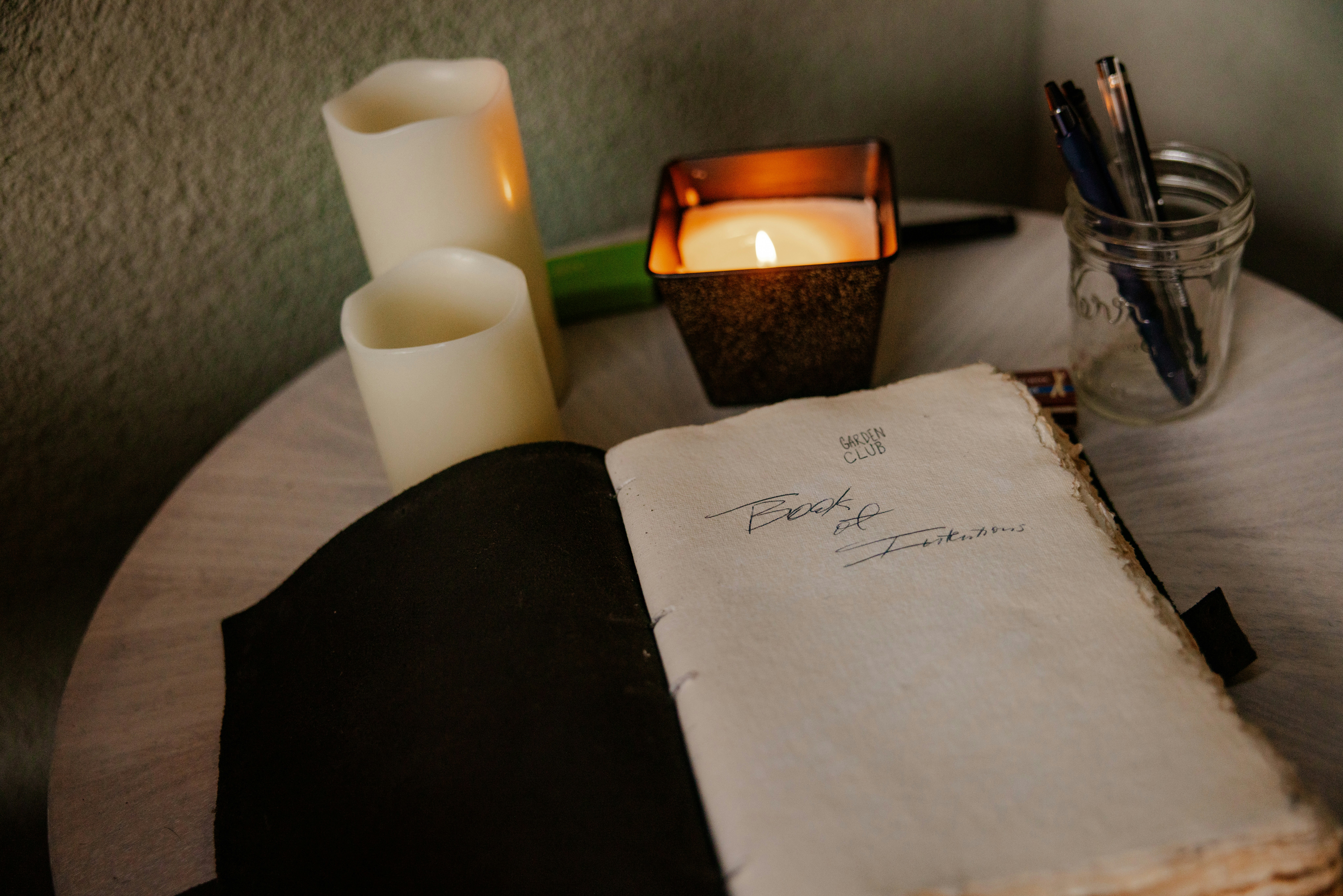 A Quiet Desk with Warm Glow: Candlelit Notes and a Weathered Journal