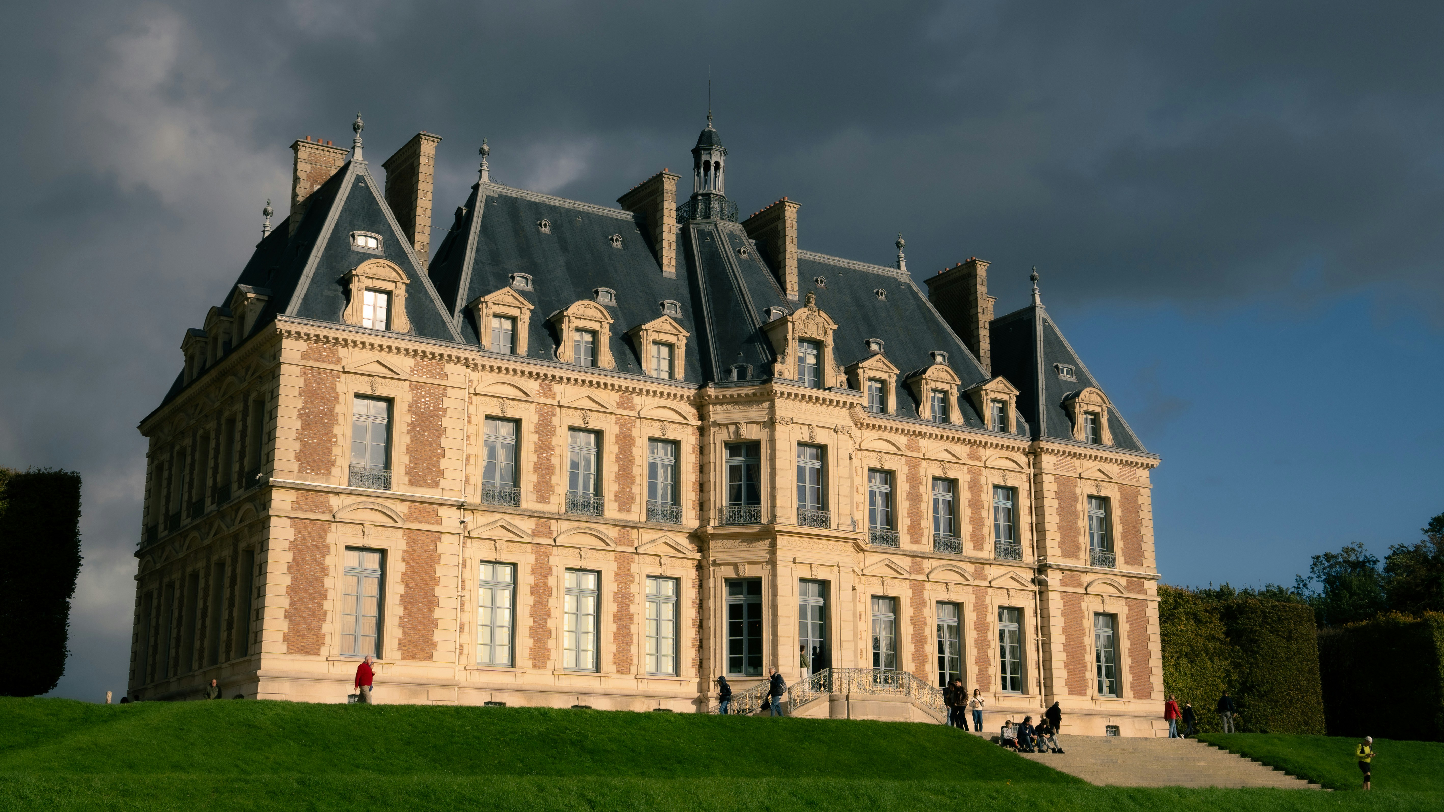 Sunlit Château: A Historic Mansion Reigns Over a Sloped Lawn
