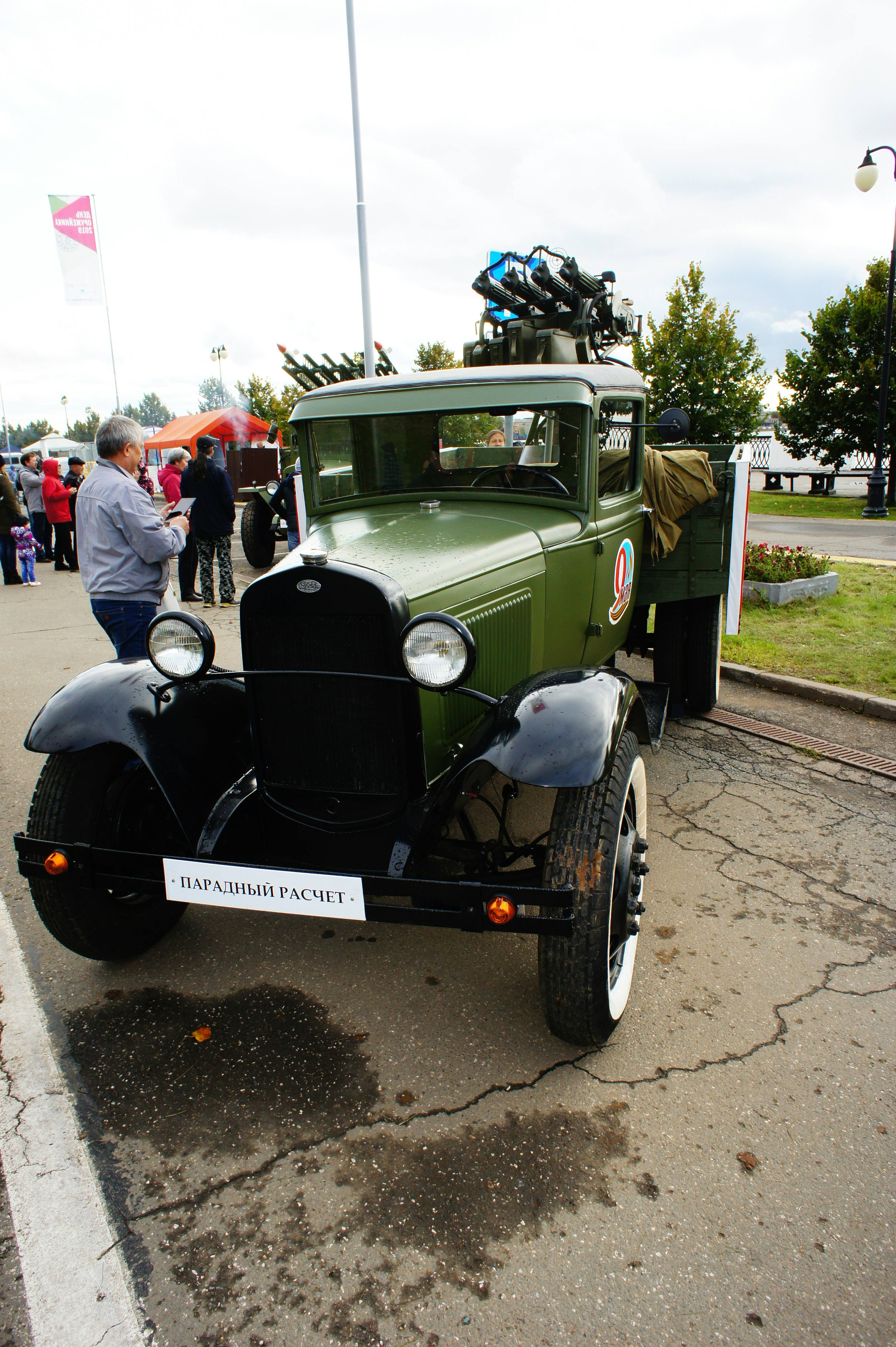 Green Retro Truck on Display with People in the Background