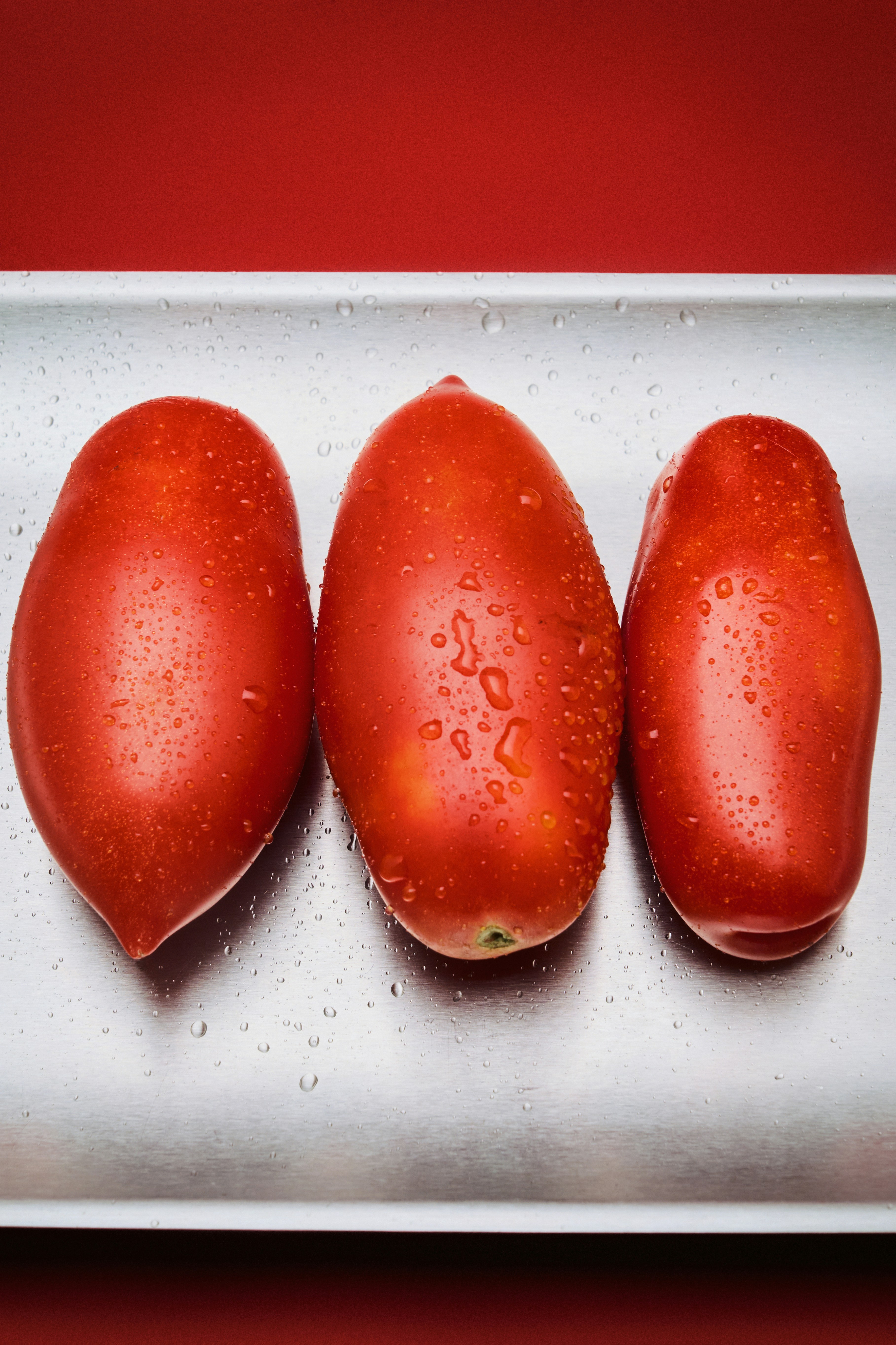 Three Red Tomatoes on a Shiny Tray
