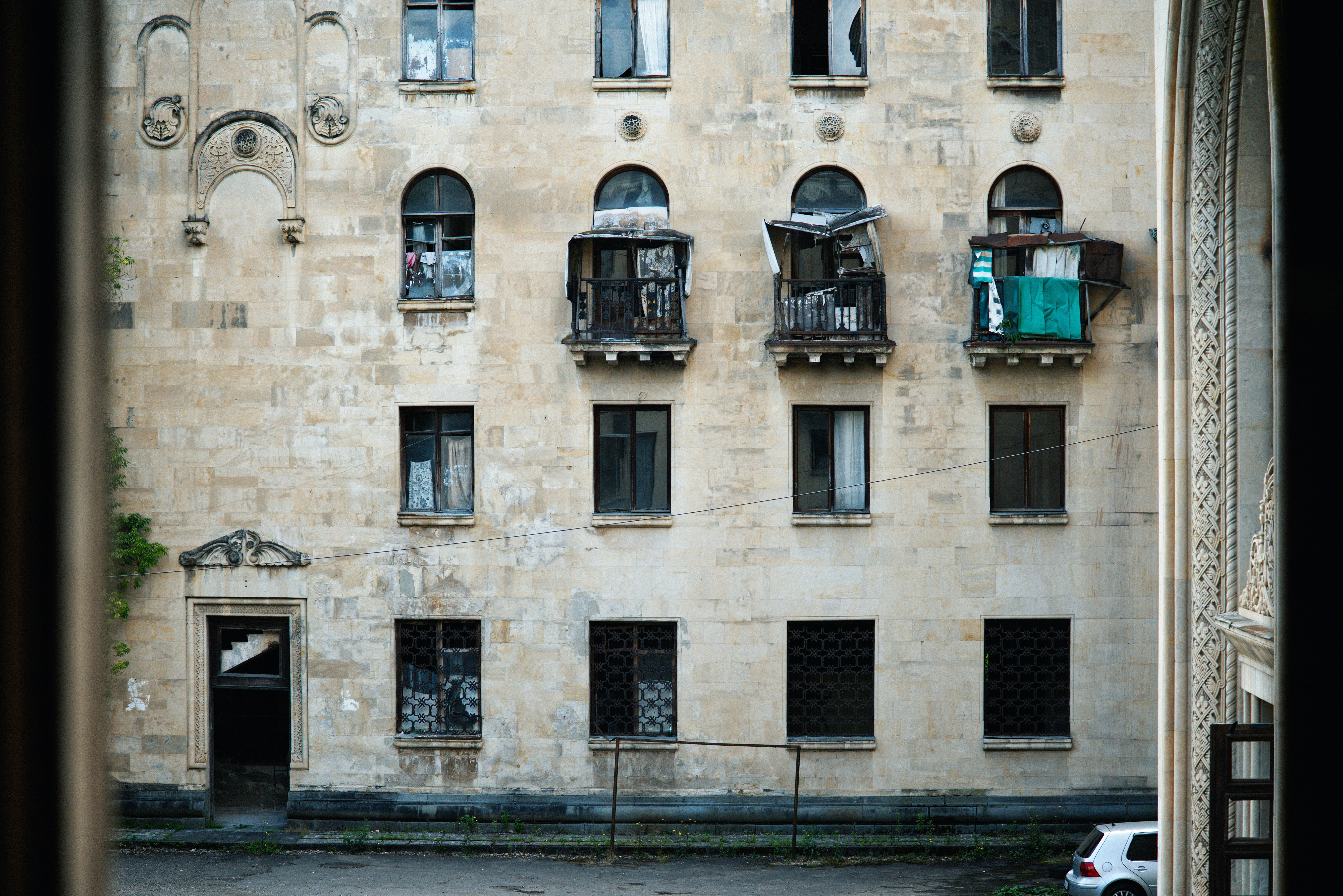Balconies of Quiet Decay in a Stone Courtyard