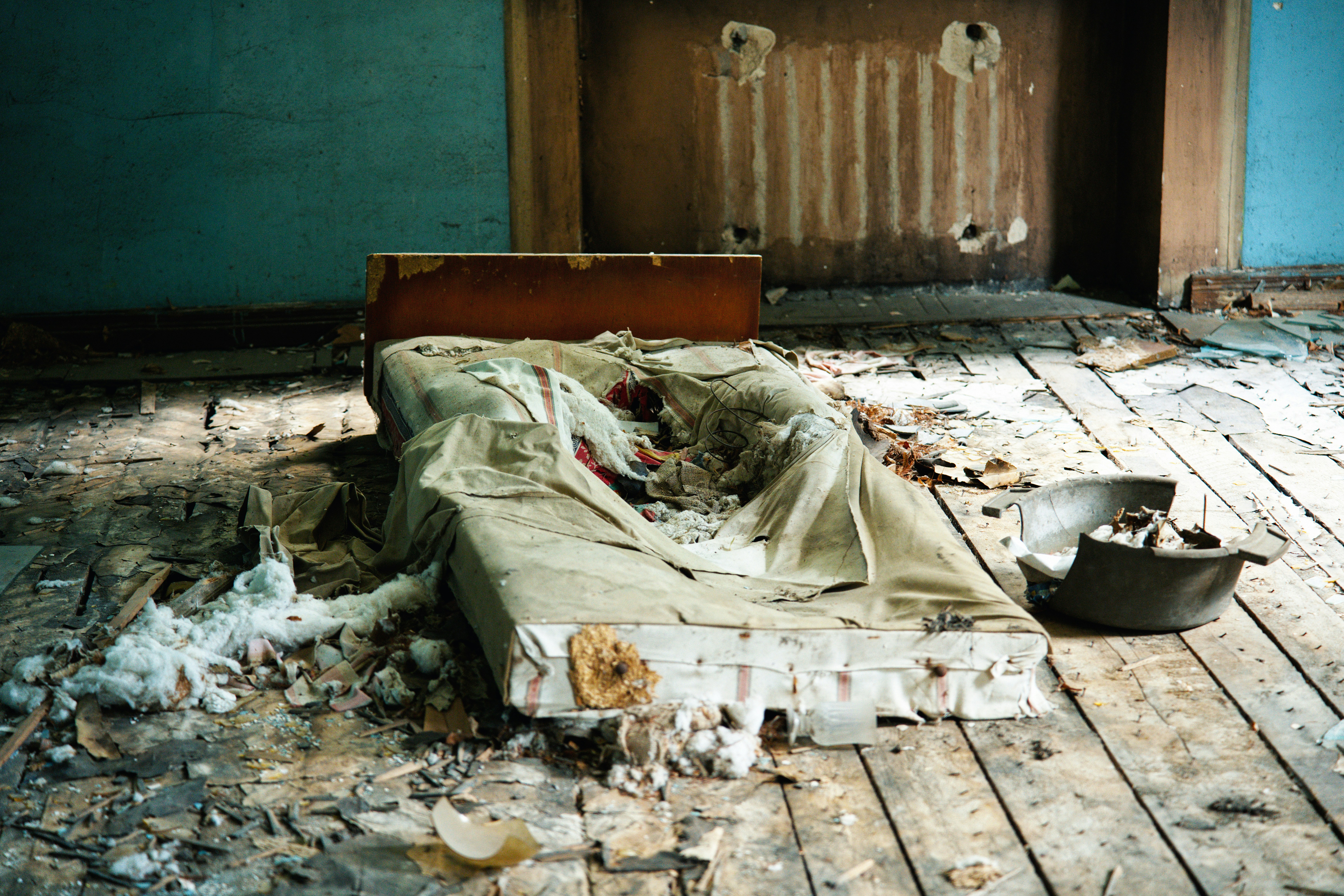 Deserted Bedroom: Frayed Mattress and Debris in an Abandoned House
