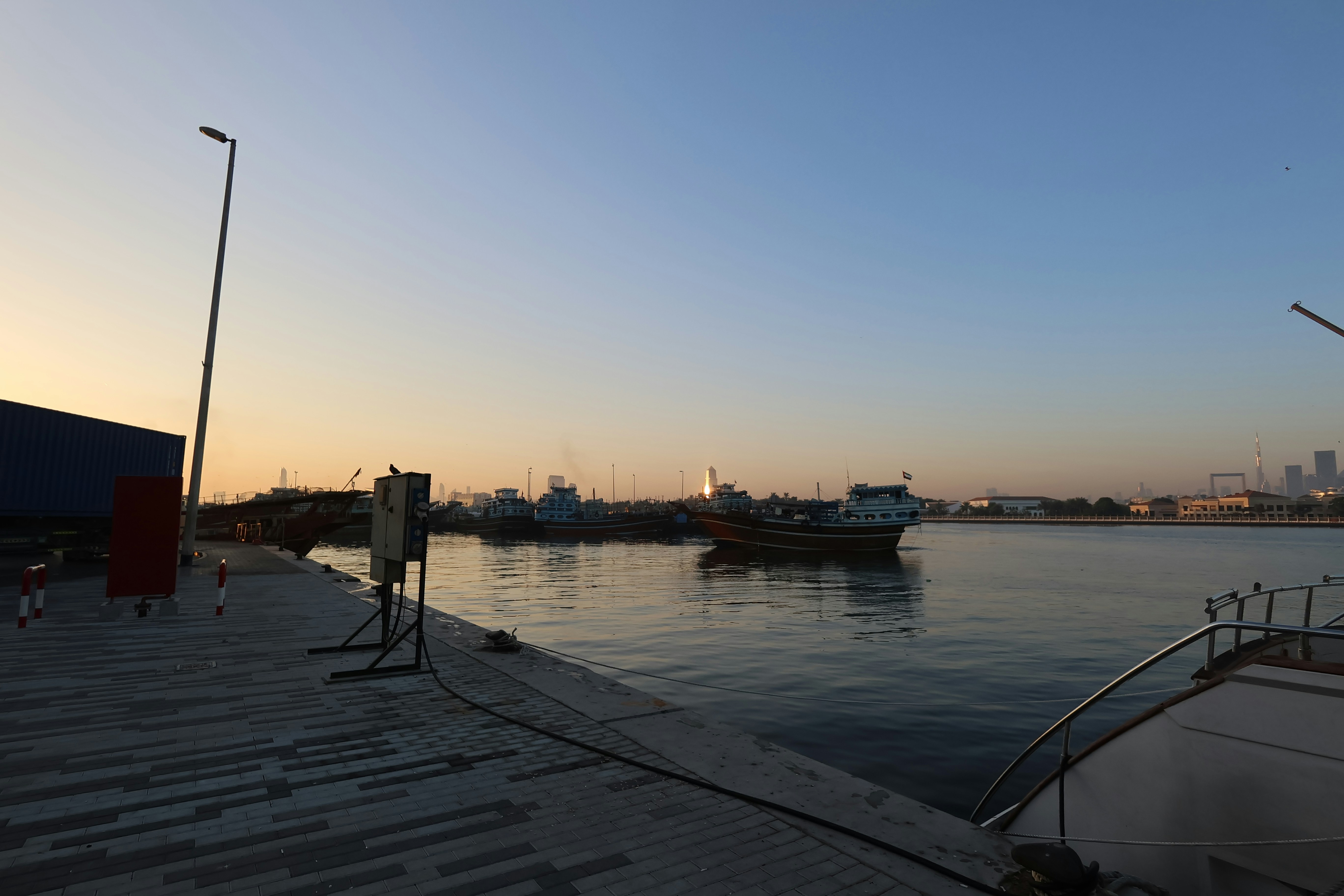 Distant harbor at golden hour with moored boats and calm waters