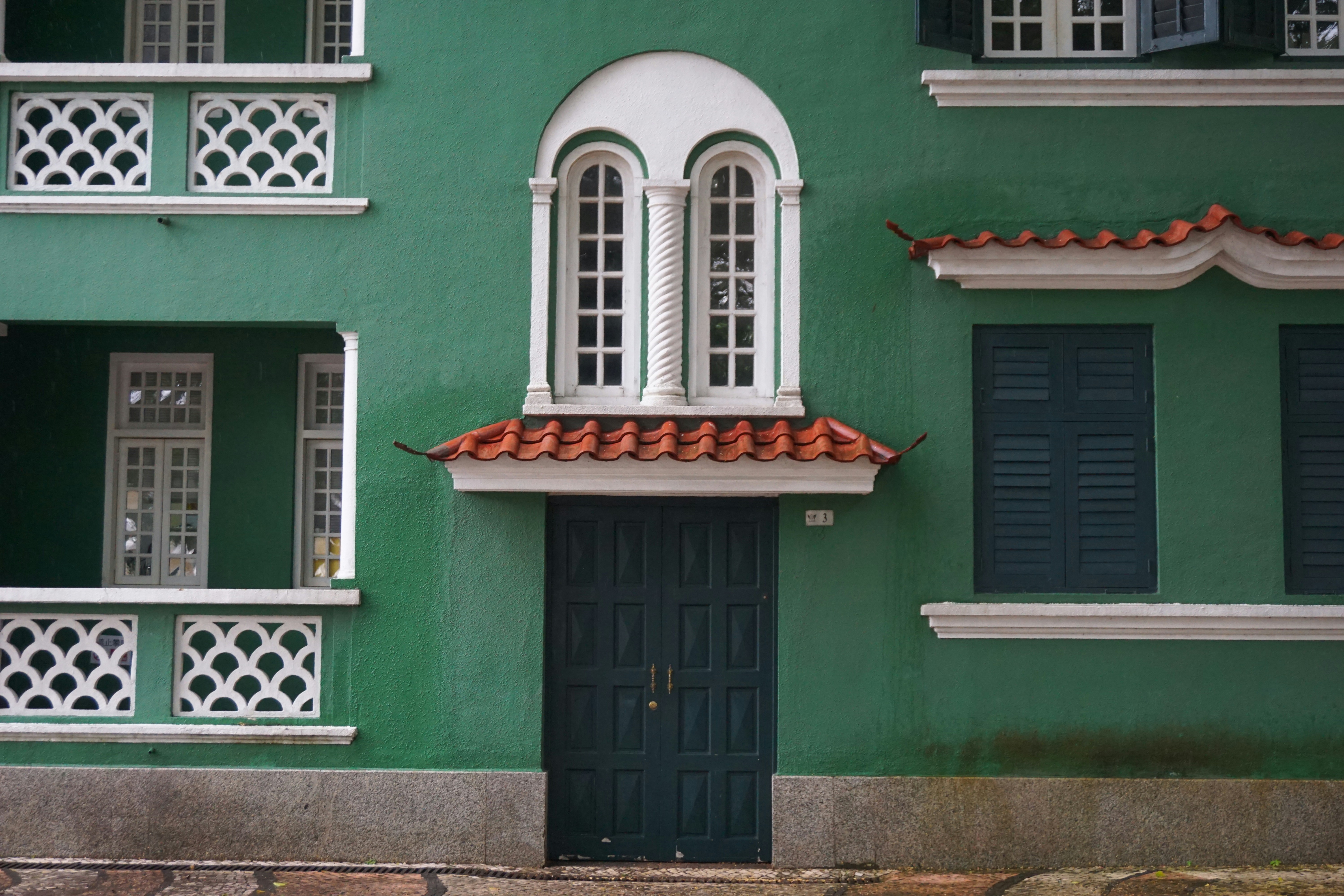 Emerald Facade: A Doorway Between Windows and Grilles