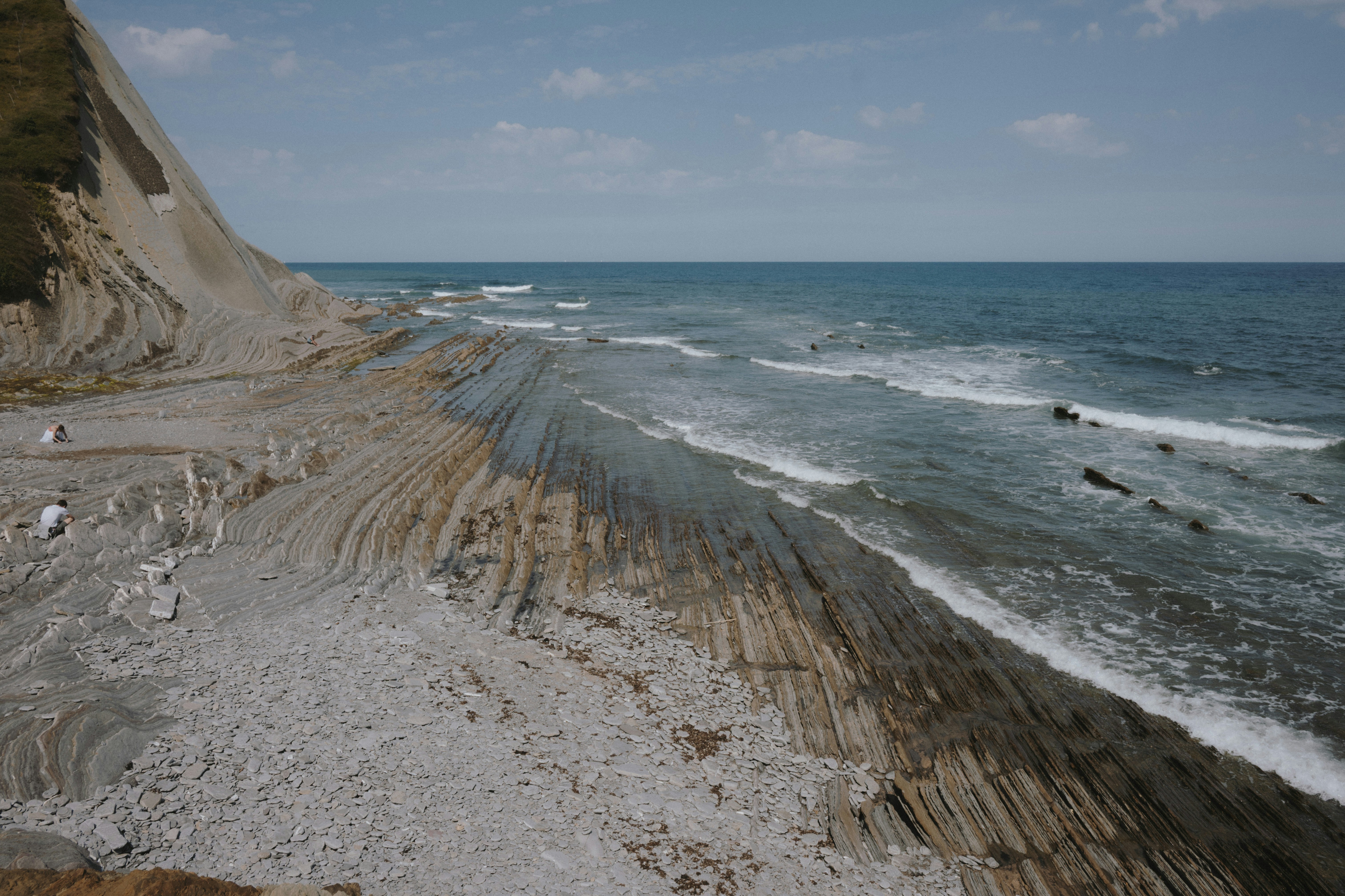 Striated Coastal Cliff meeting the Breaker-ridden Shore