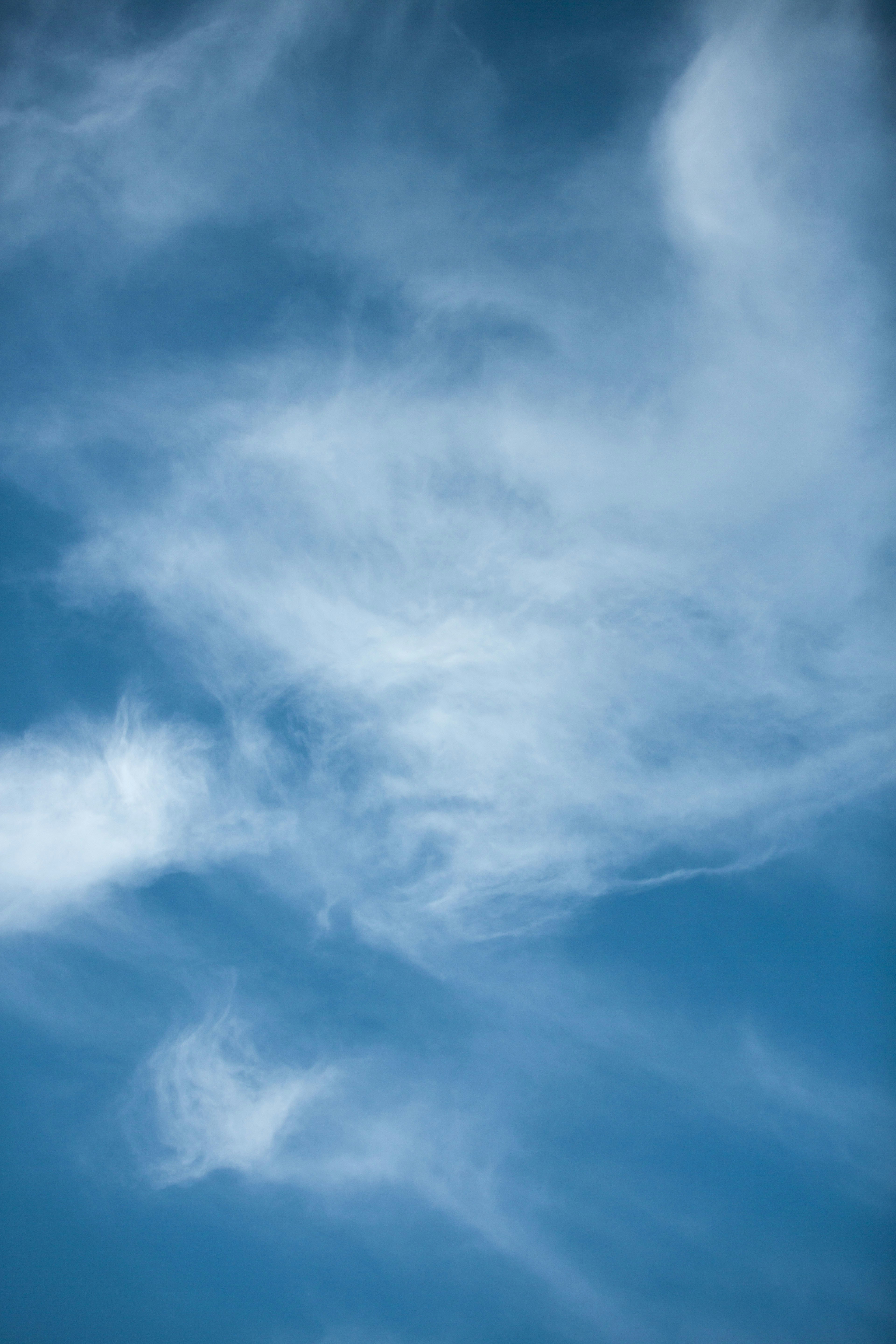 Azure Whispers: Clouds Drifting Across a Clear Sky