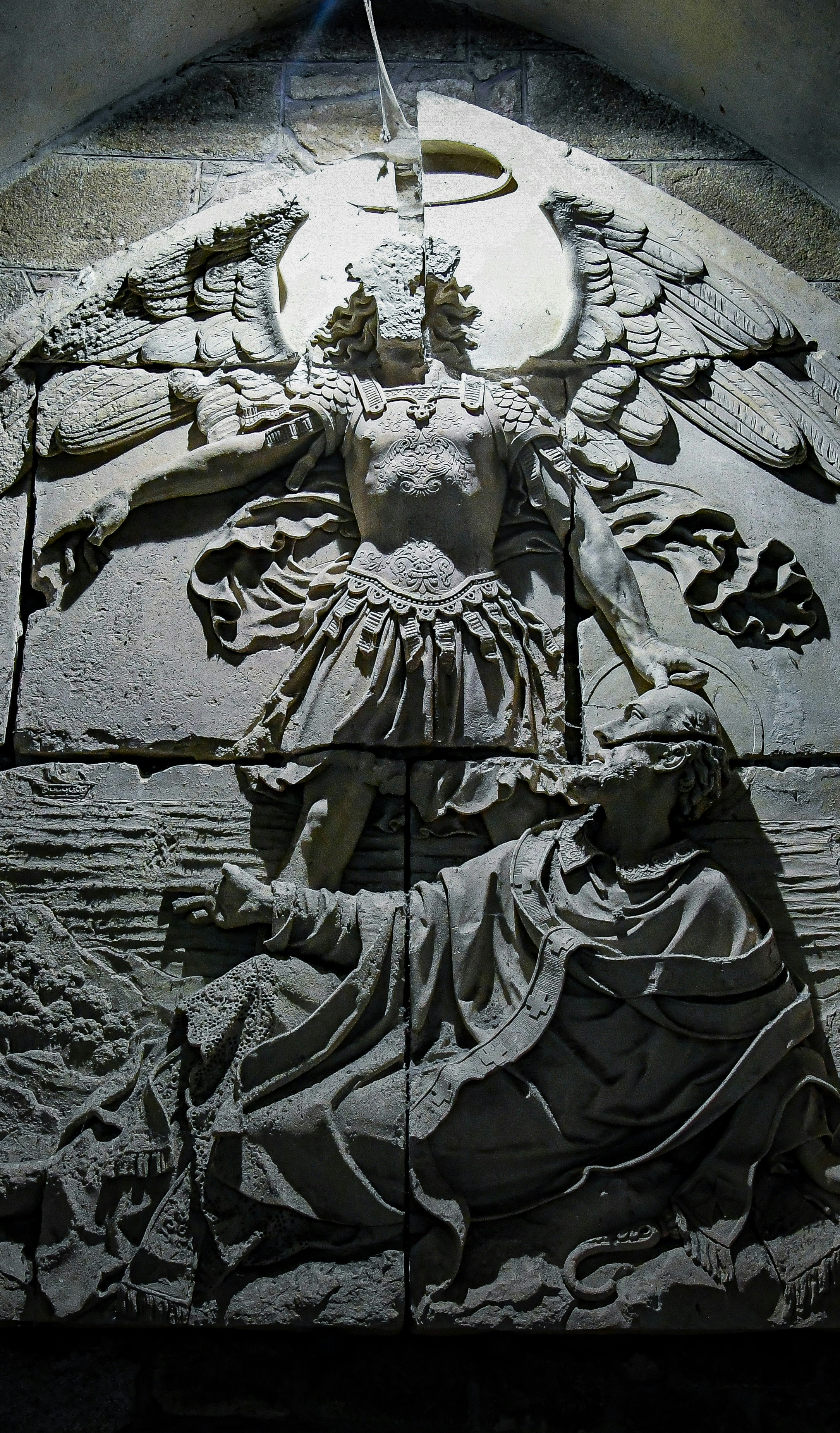 Winged Warrior and Seated Oracle: A Stone Relief in Night Light