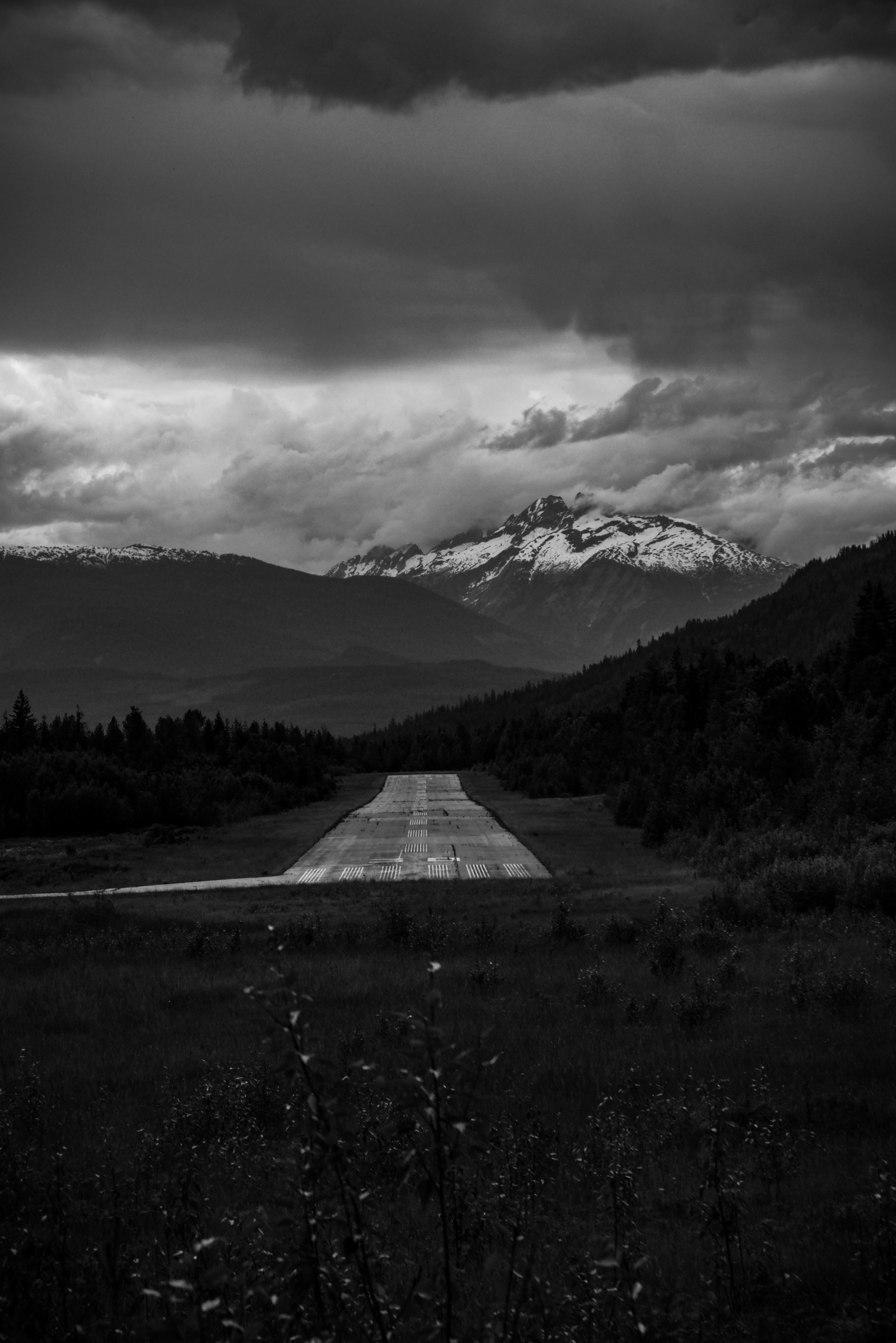 Descent into the Mountains: A Quiet Runway Framed by Storm Clouds